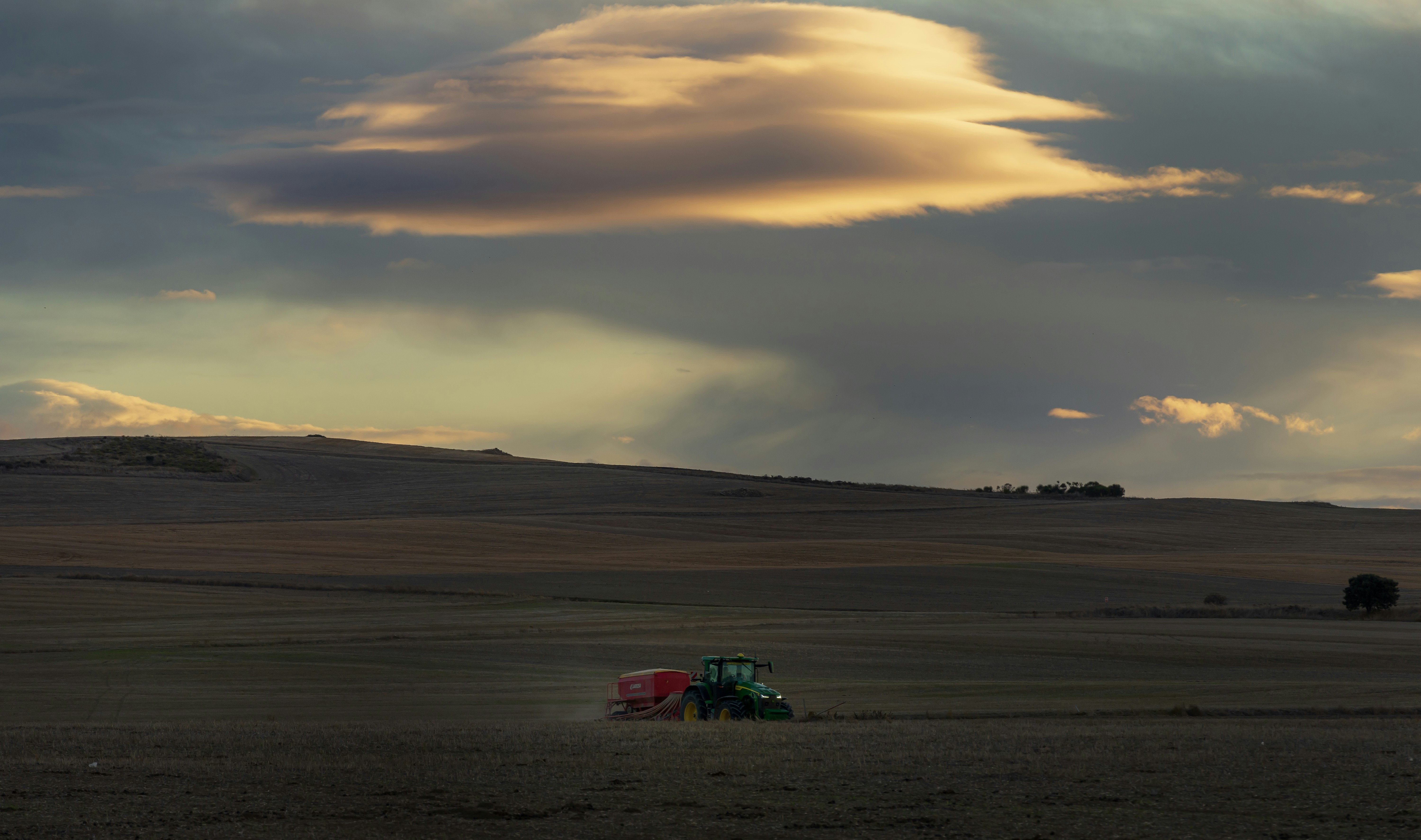 Harvest in Silence: Tractor at Dusk on a Prairie