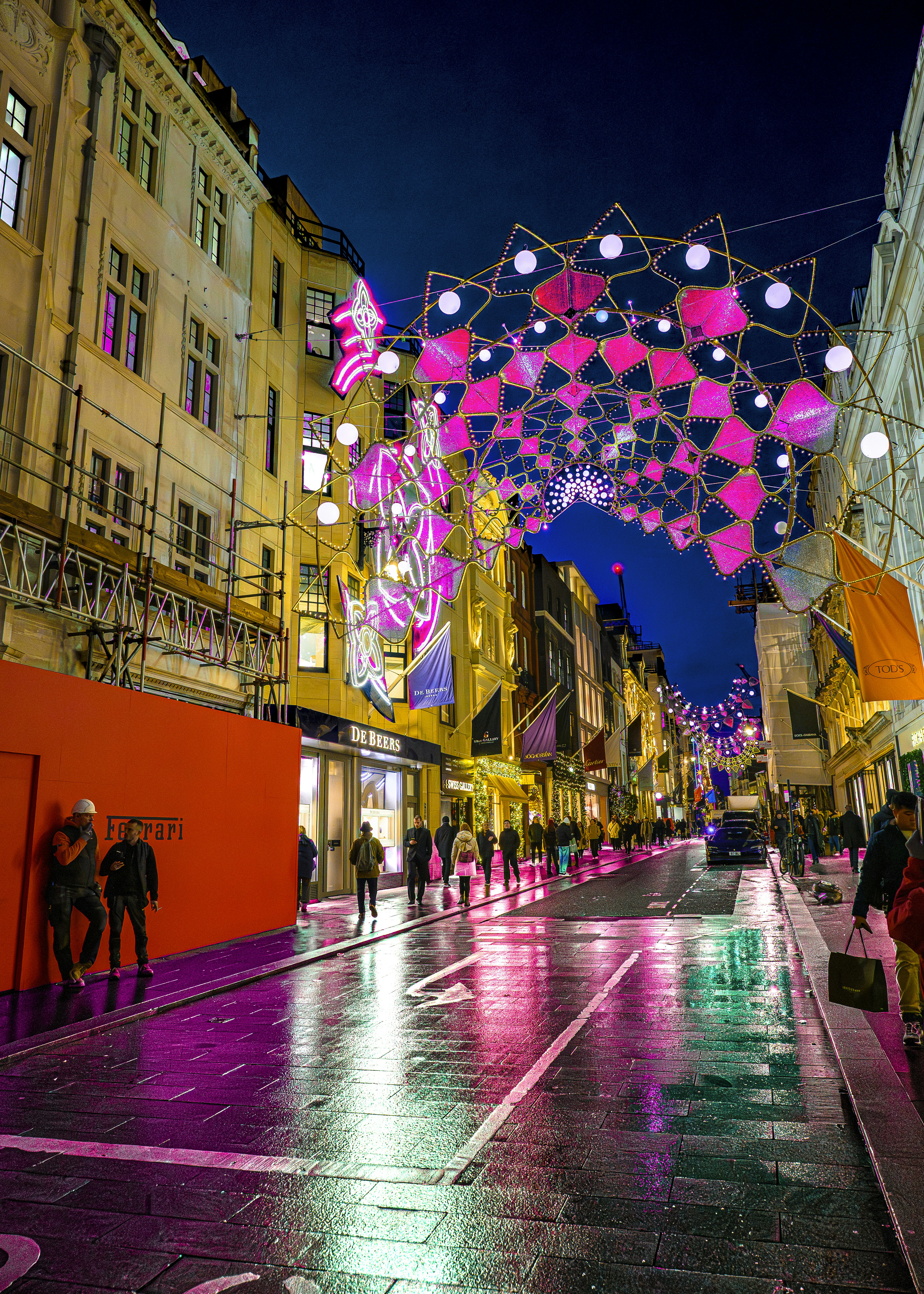Night Street Under Neon Lace: Festive Lights Reflect on Wet Pavement