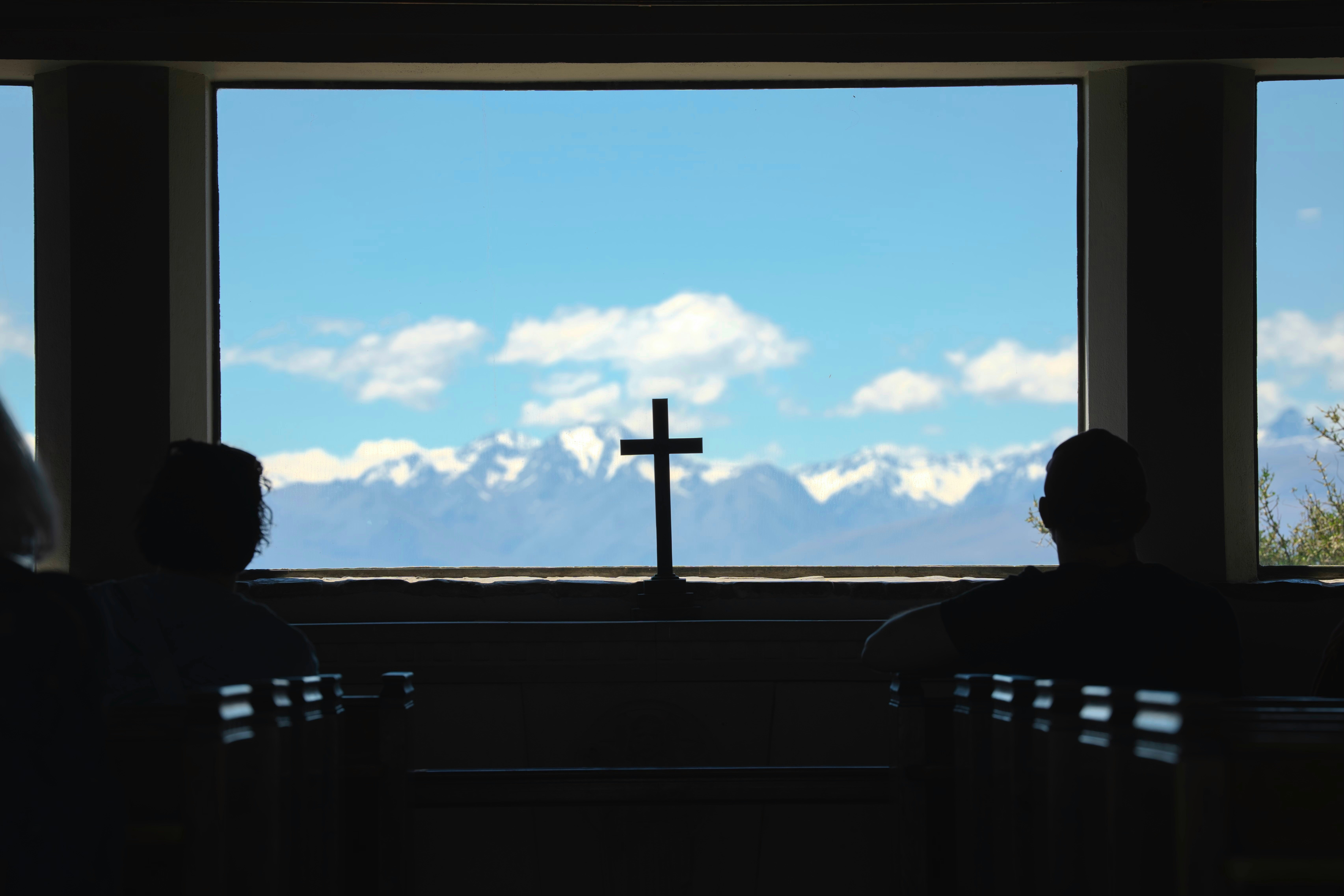 Silhouette in the Chapel Overlooking Snow-Capped Peaks