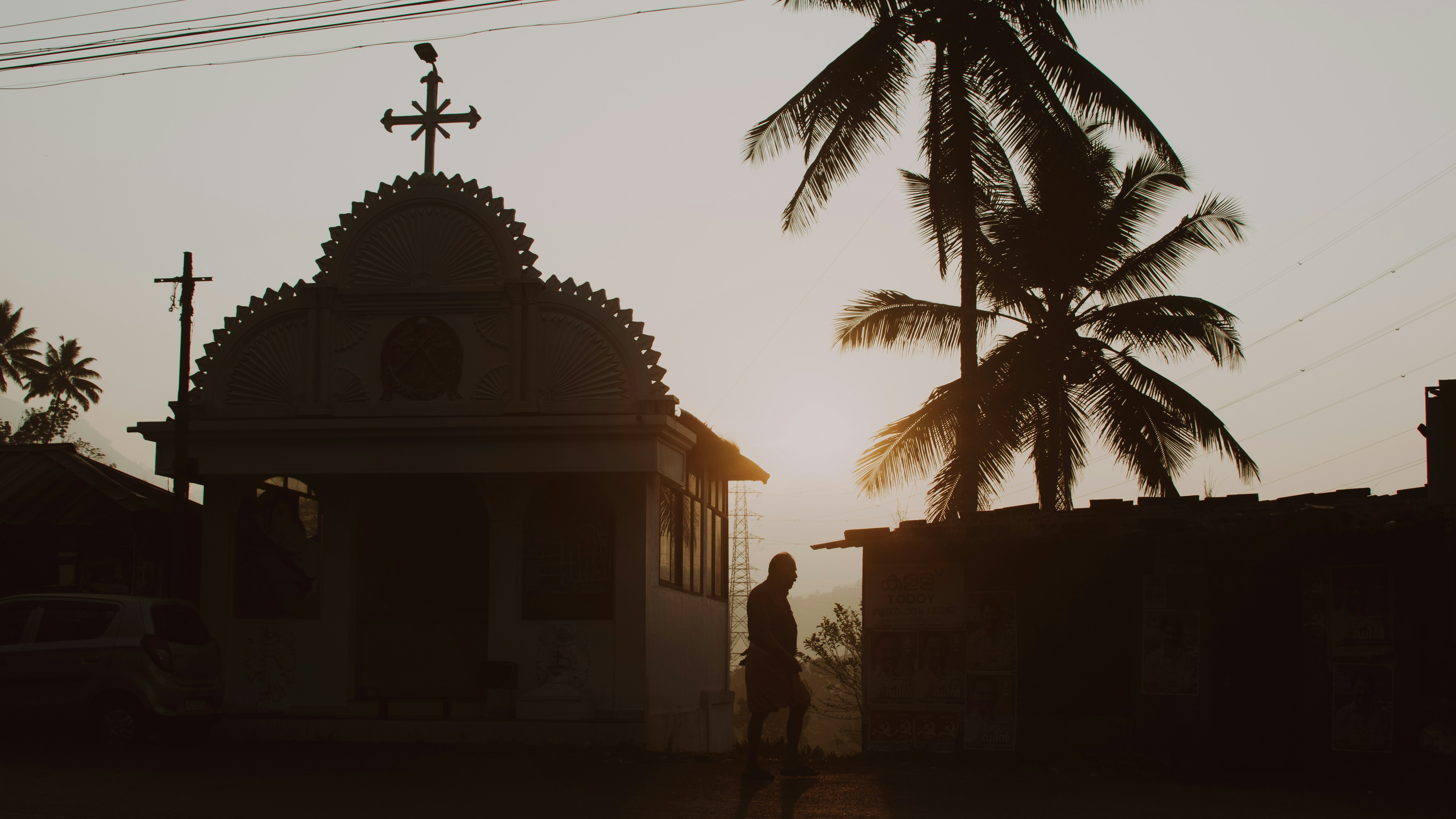 Silhouette at Dusk: A Palm-Fringed Shrine and Quiet Street