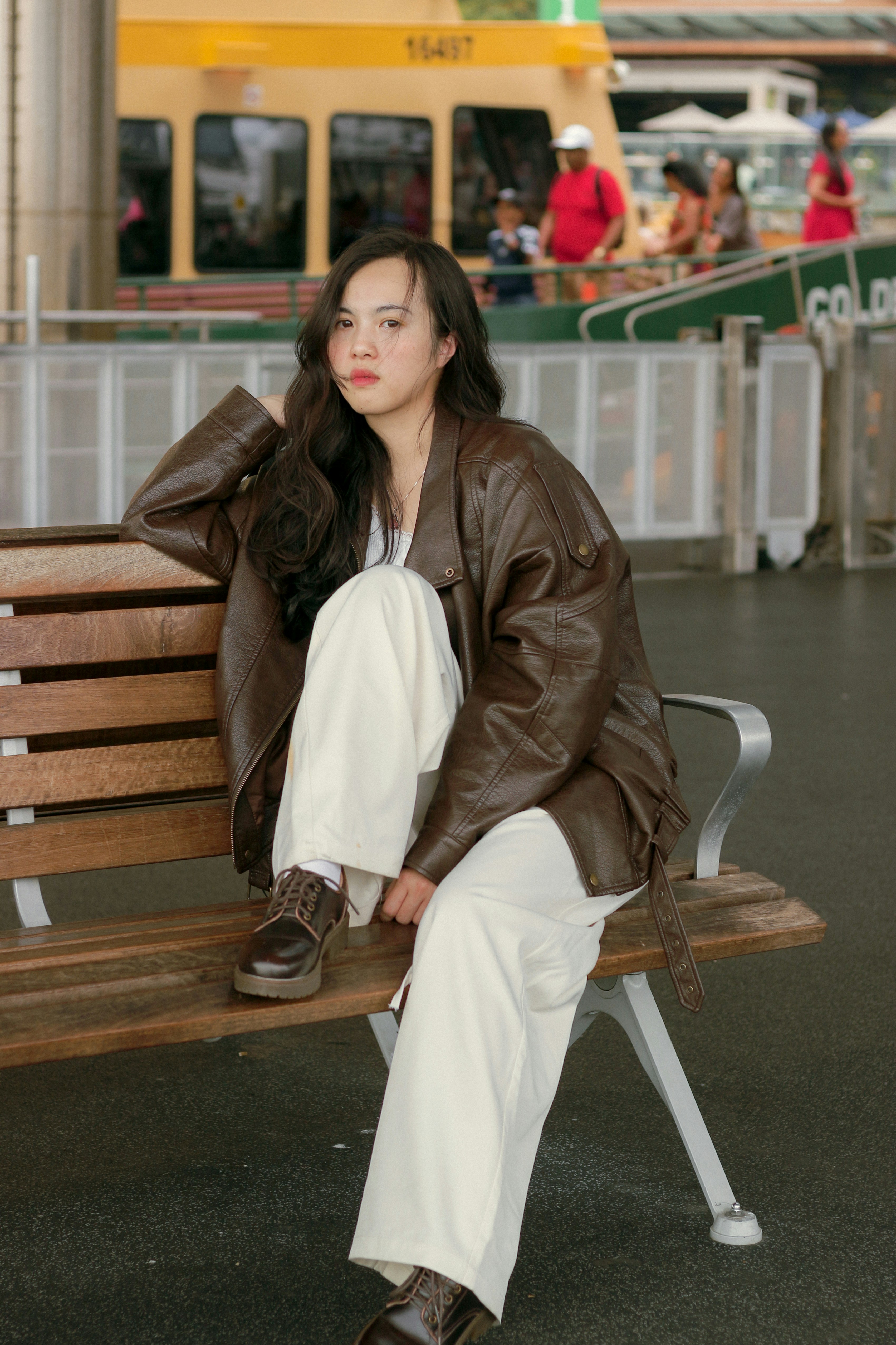 Leathered Quiet: A City Bench Portrait Against a Moving Waterfront