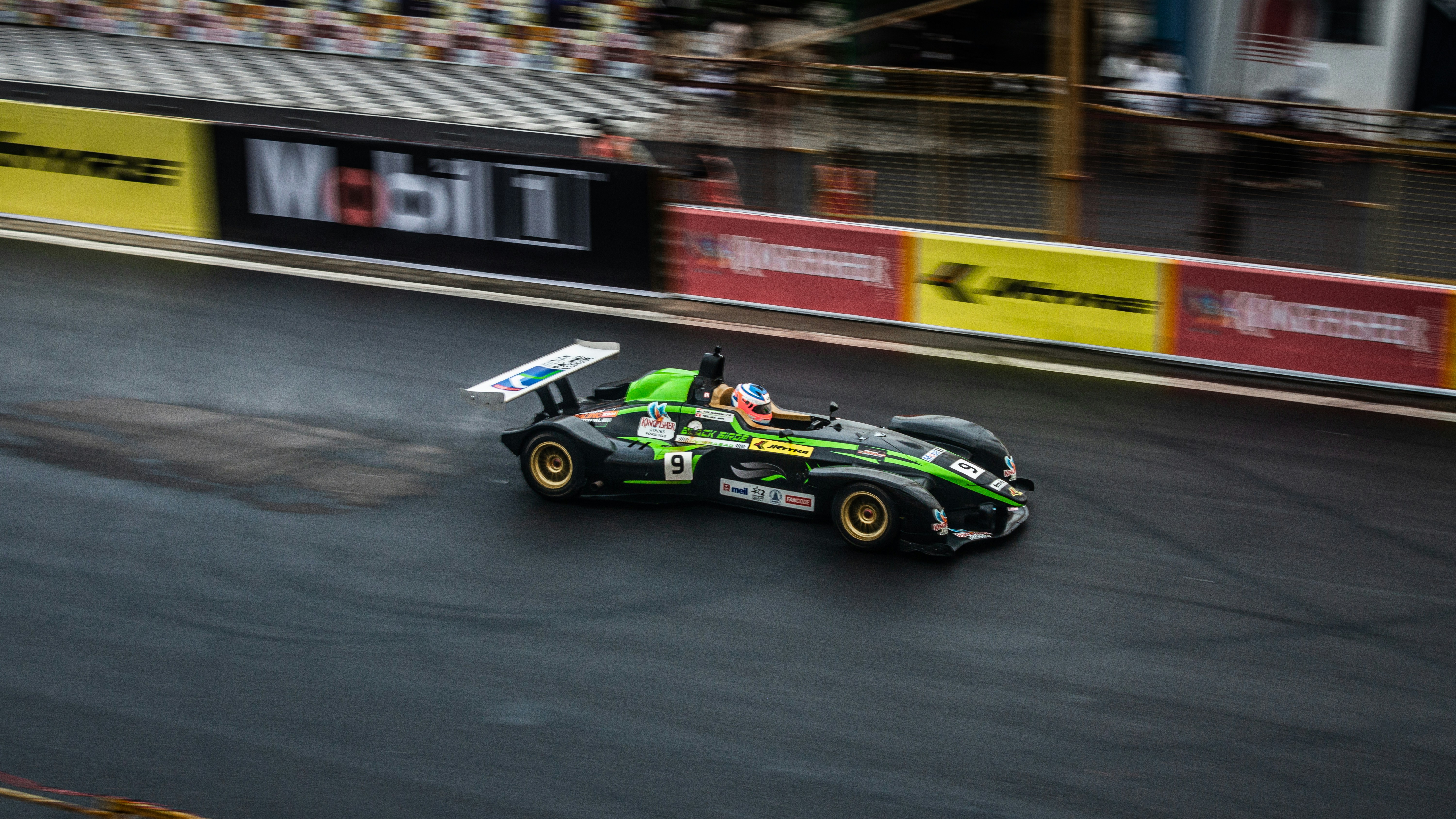 A green race car speeds down a track. photo – Free Vehicle Image on ...