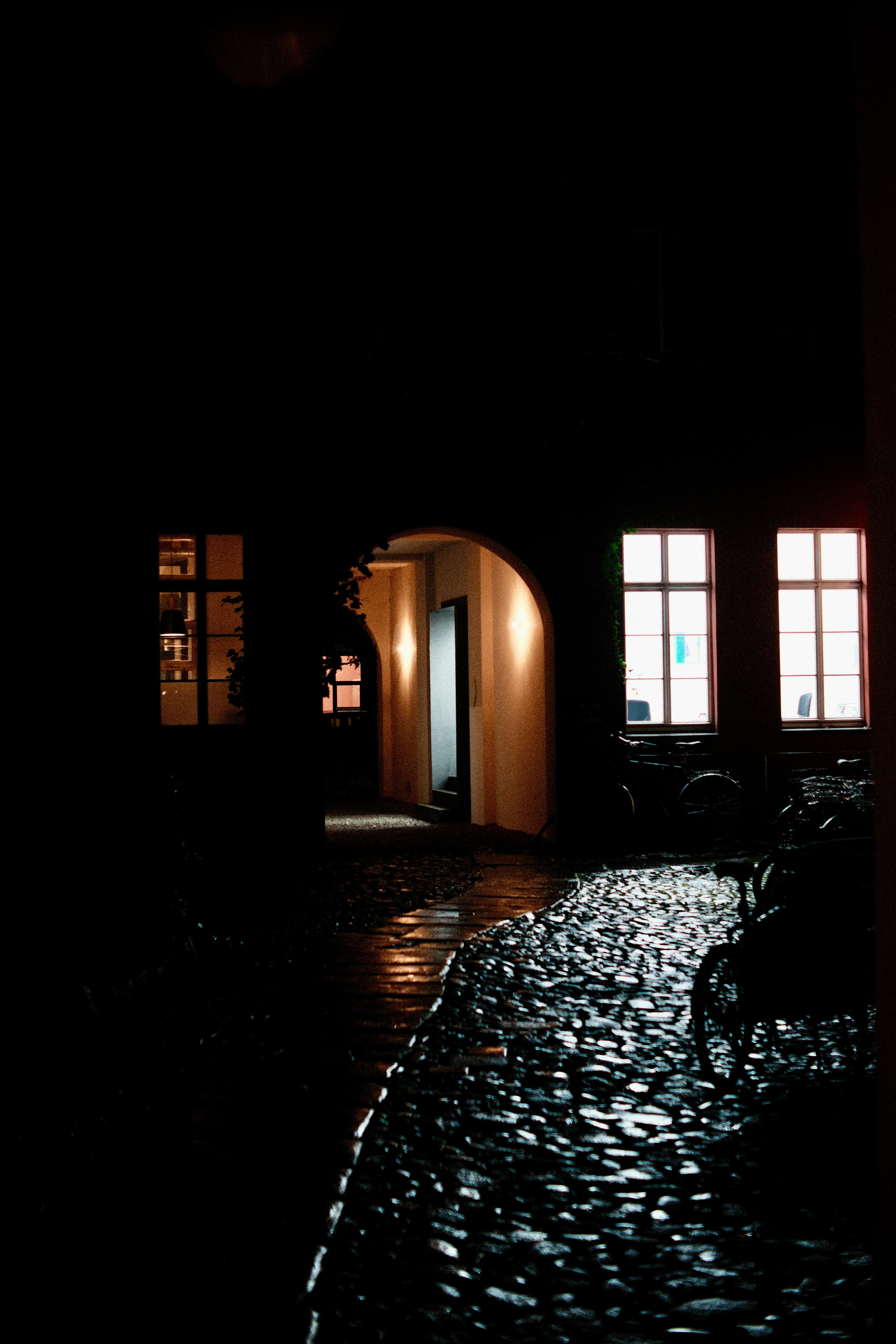 Moonlit Arcade: Warm Light Framing a Cobblestone Path