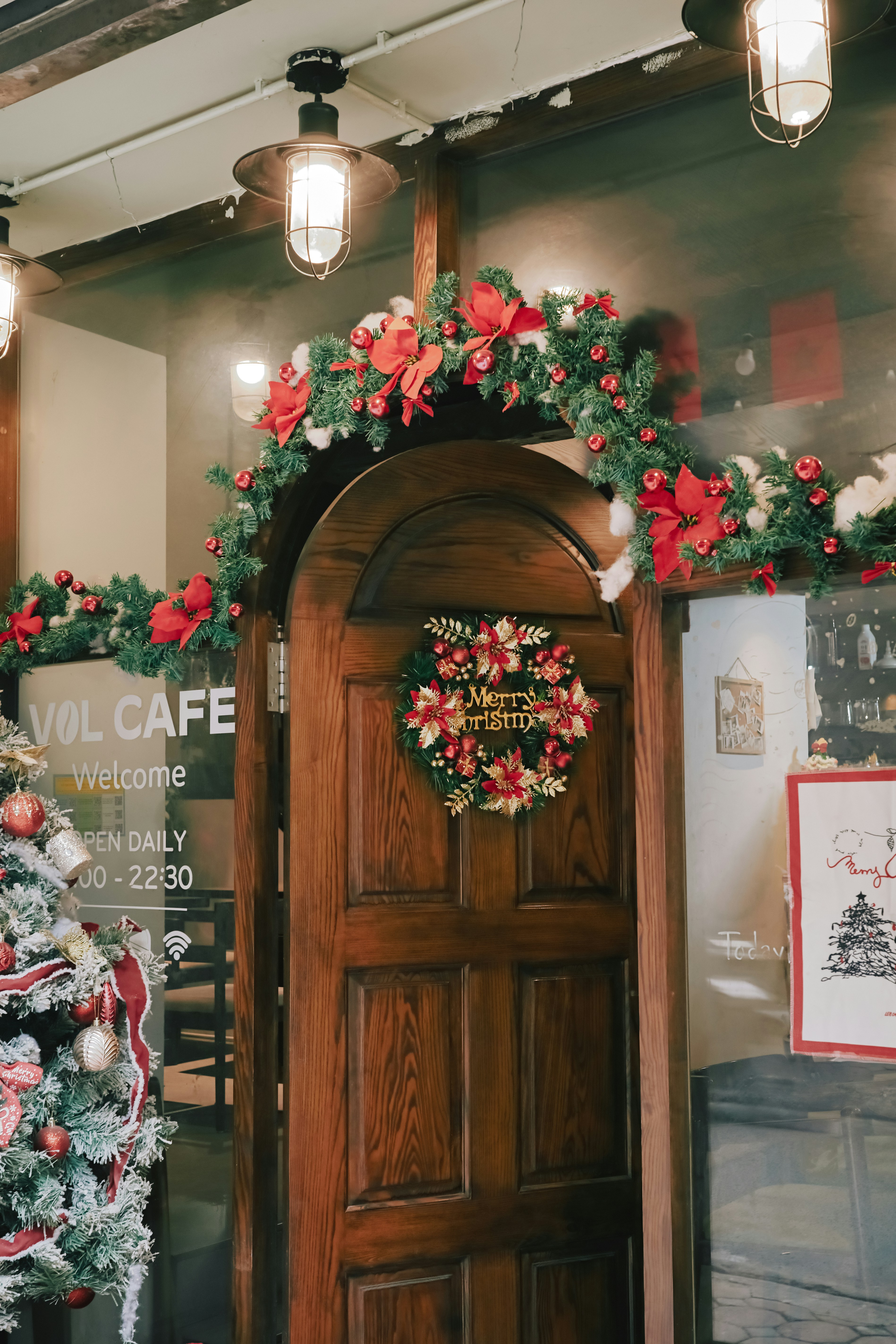 A Festive Doorway Framed by Garland and Greeting Lights