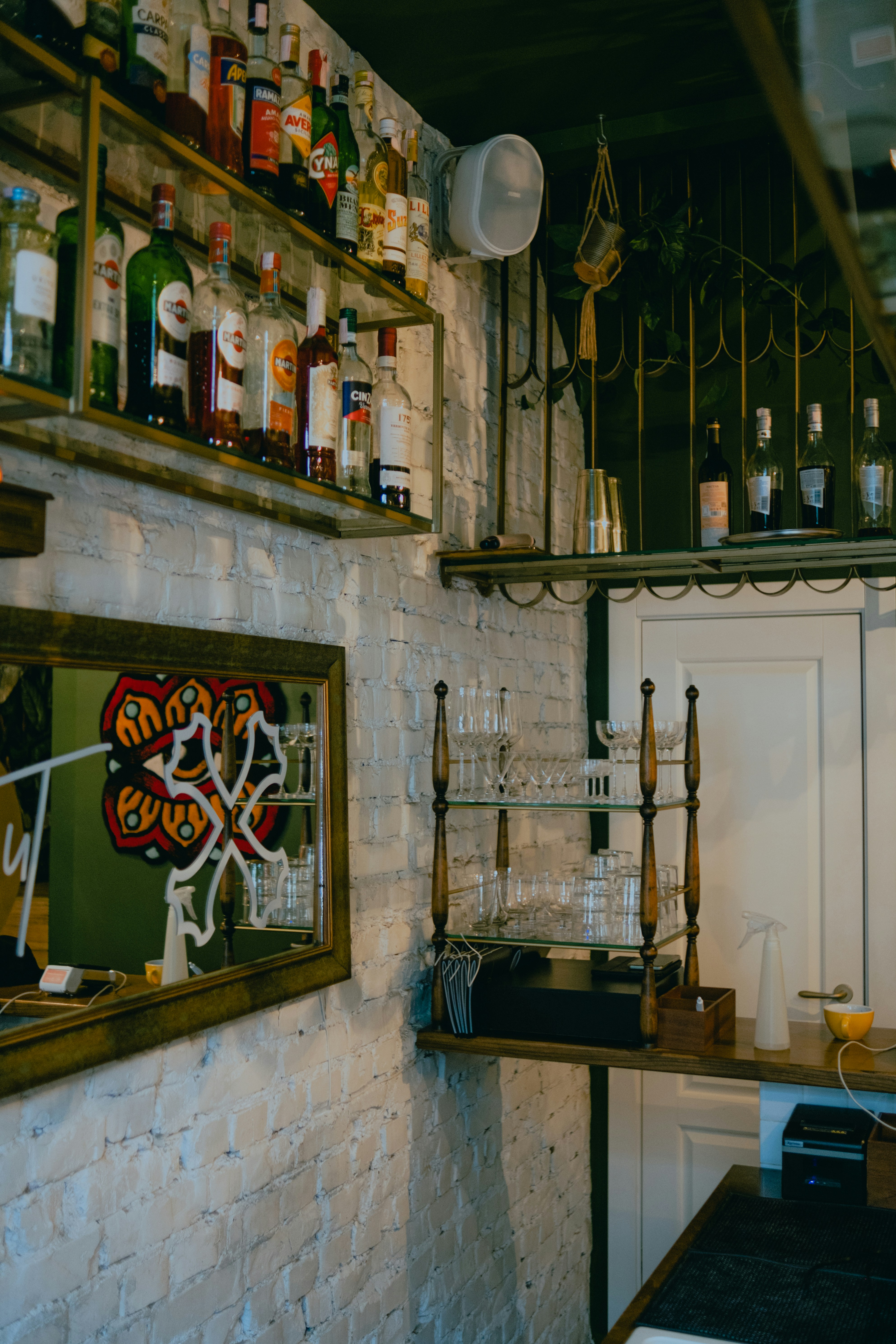 Shelf of Spirits and Glassware in a Brick-Walled Bar