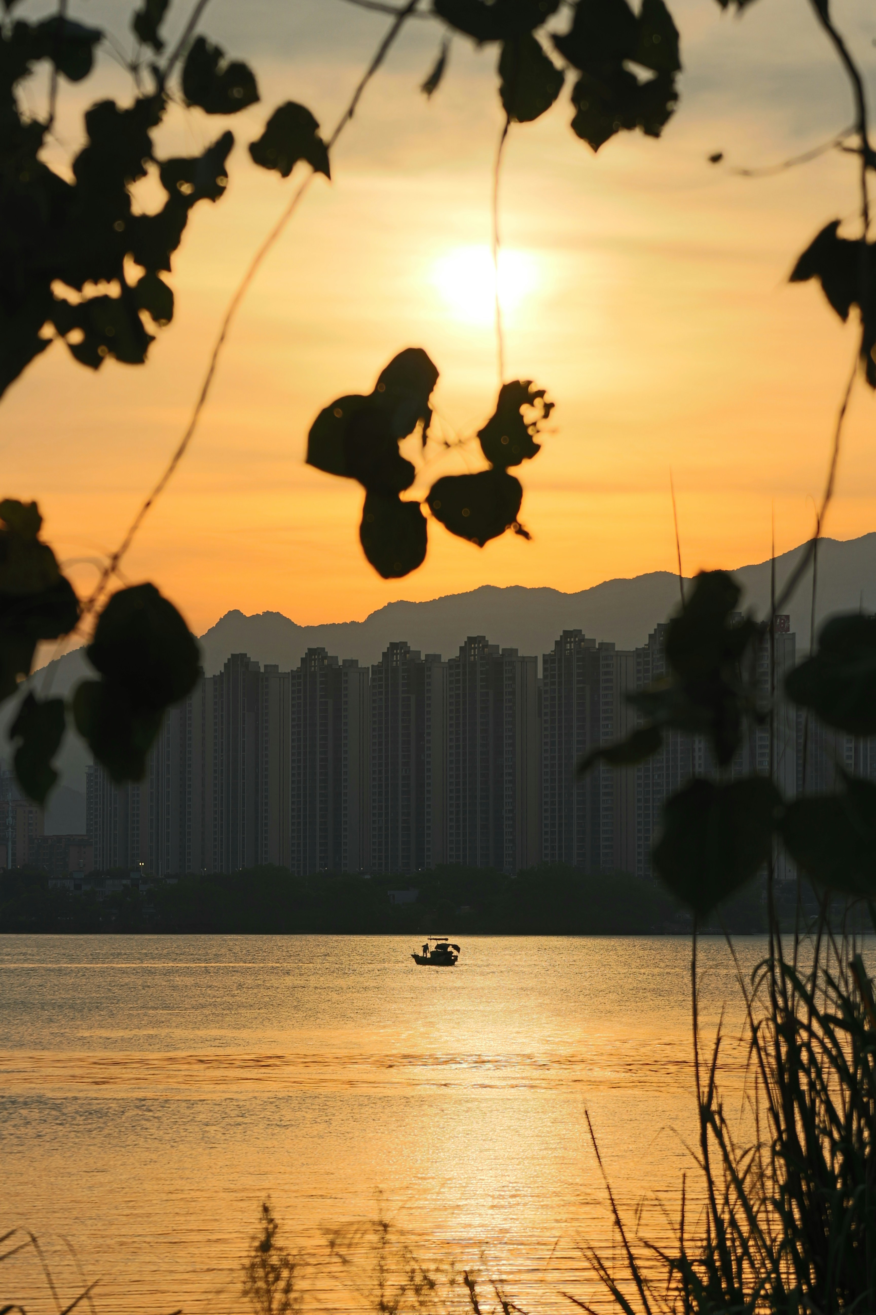 Sunset over the Dam: A Quiet Boat Between Skyline and Reflections