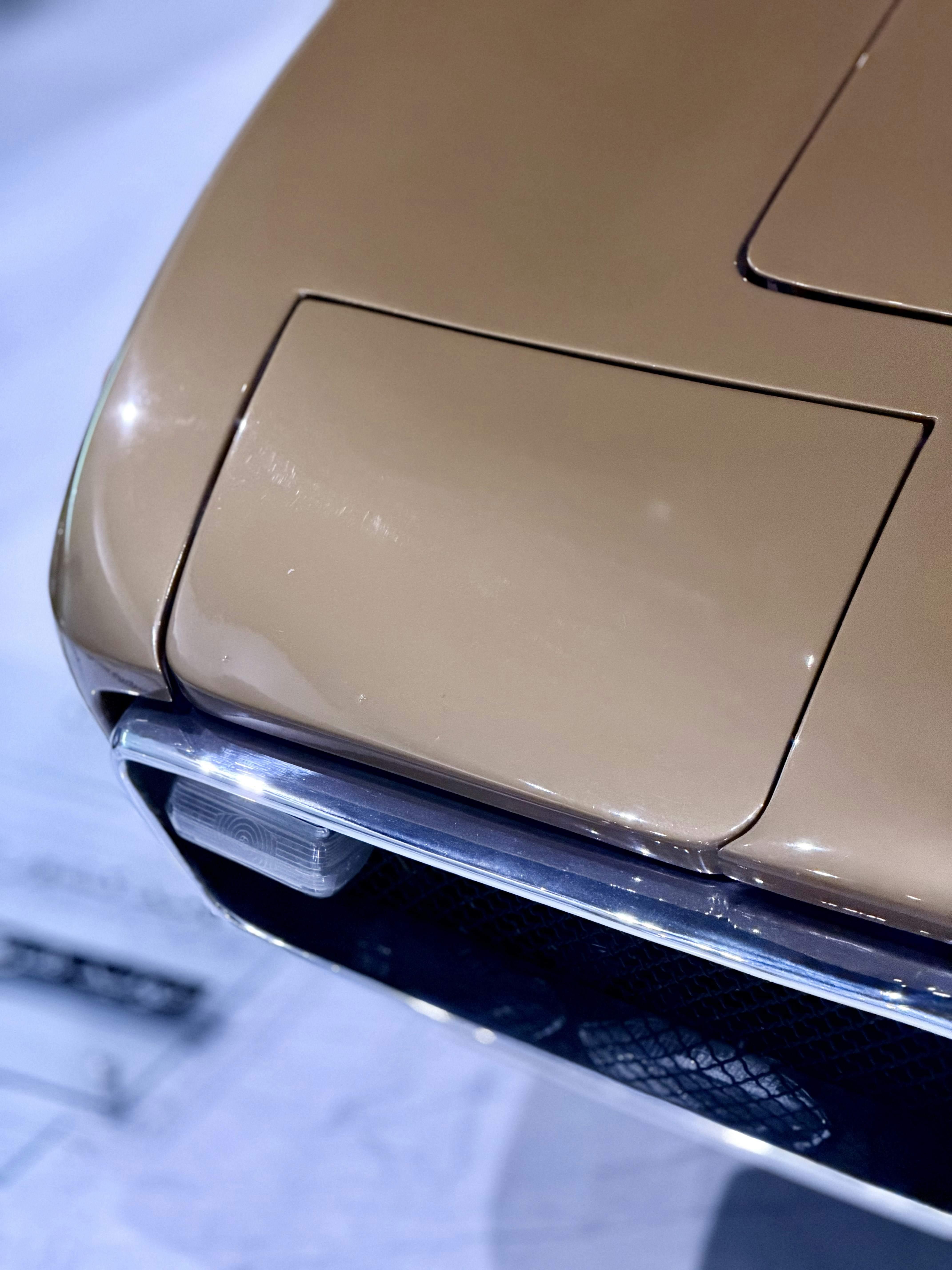 Hooded gull-blue chrome: a close-up of a classic car hood and headlamp corner