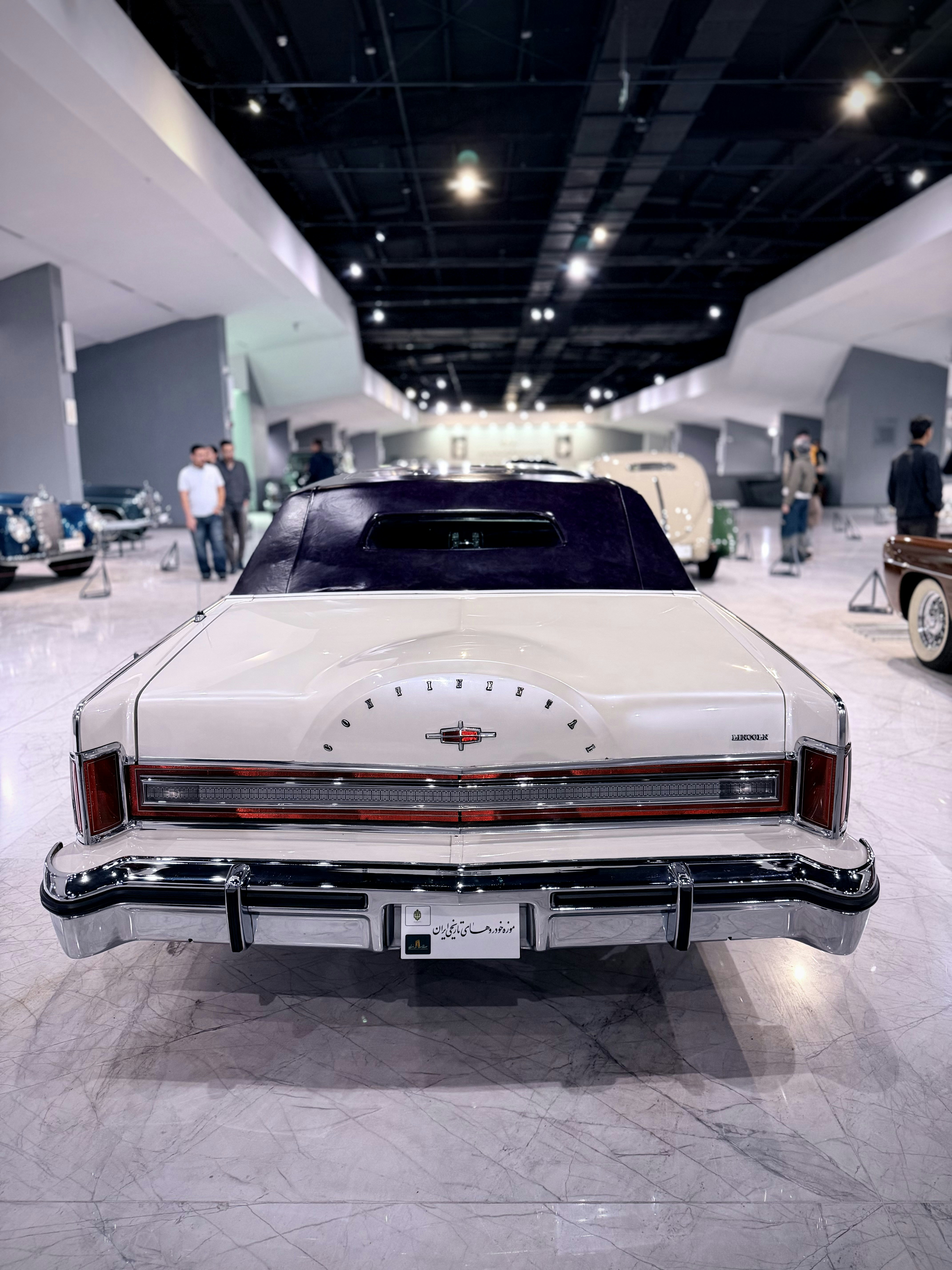 Rearview Classic: A Vintage Convertible Crowned in Exhibition Hall Light
