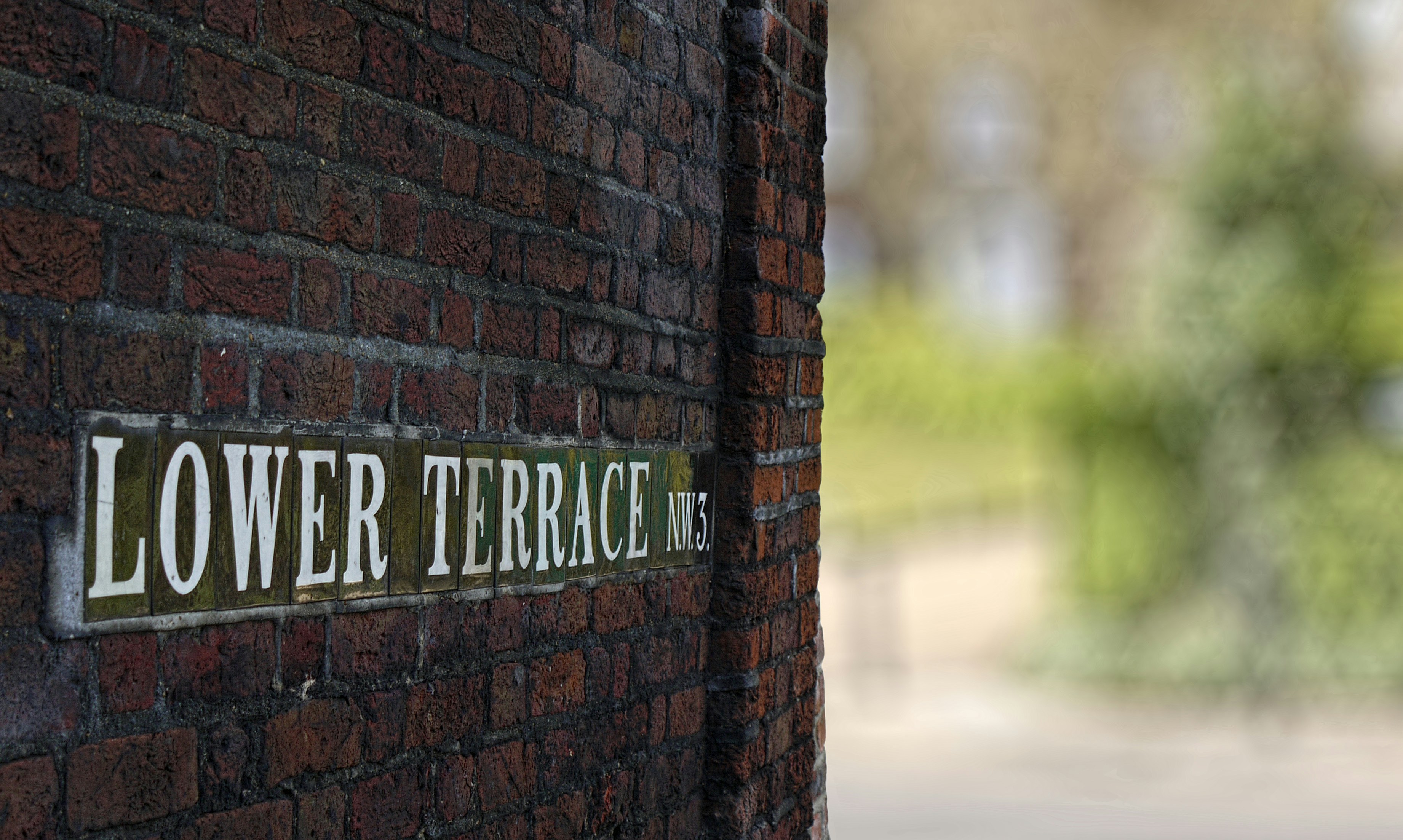 Street sign for lower terrace on brick wall