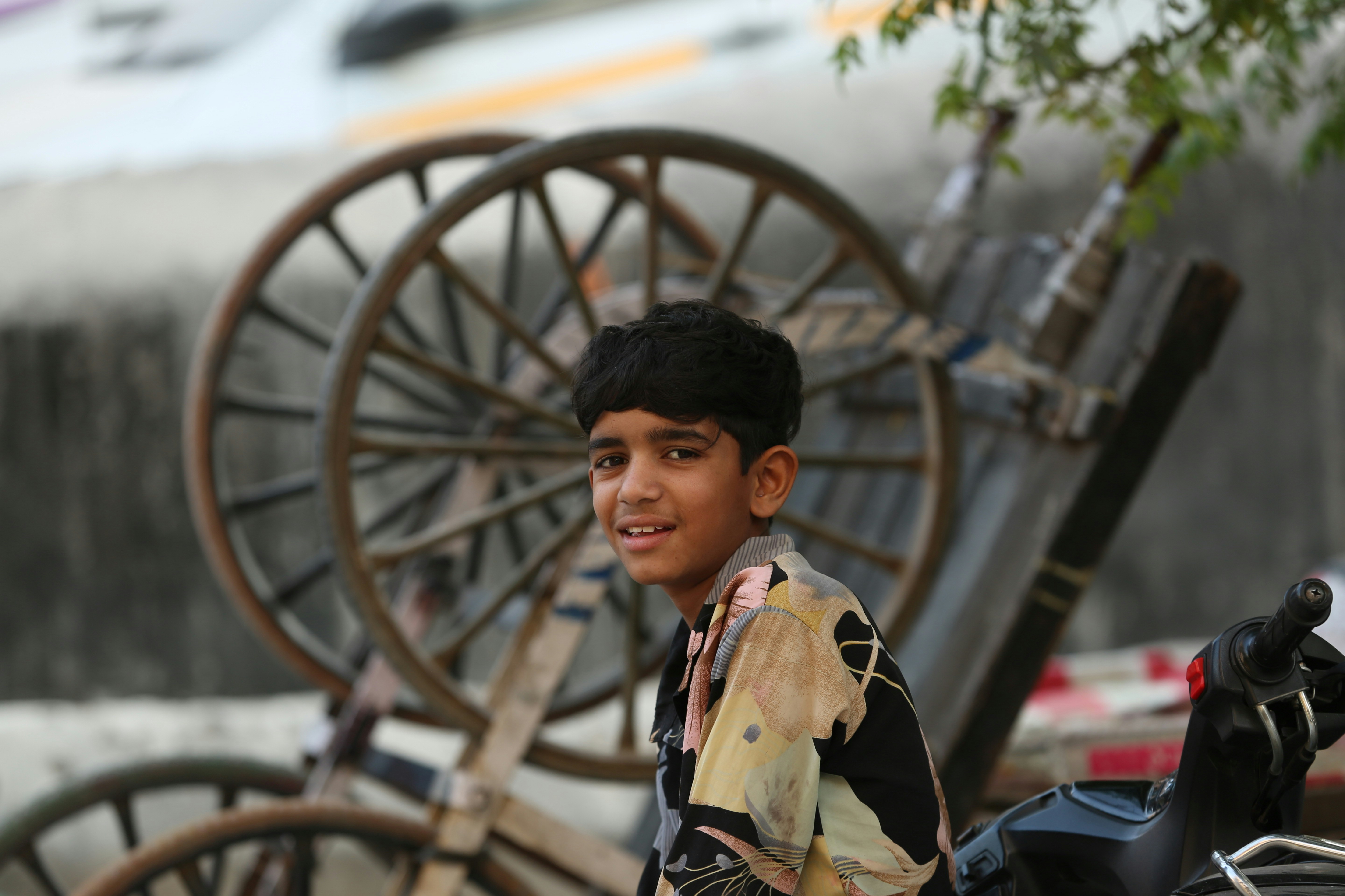 Smiling Boy with Spinning Wheel: Quiet Moment by the Workshop