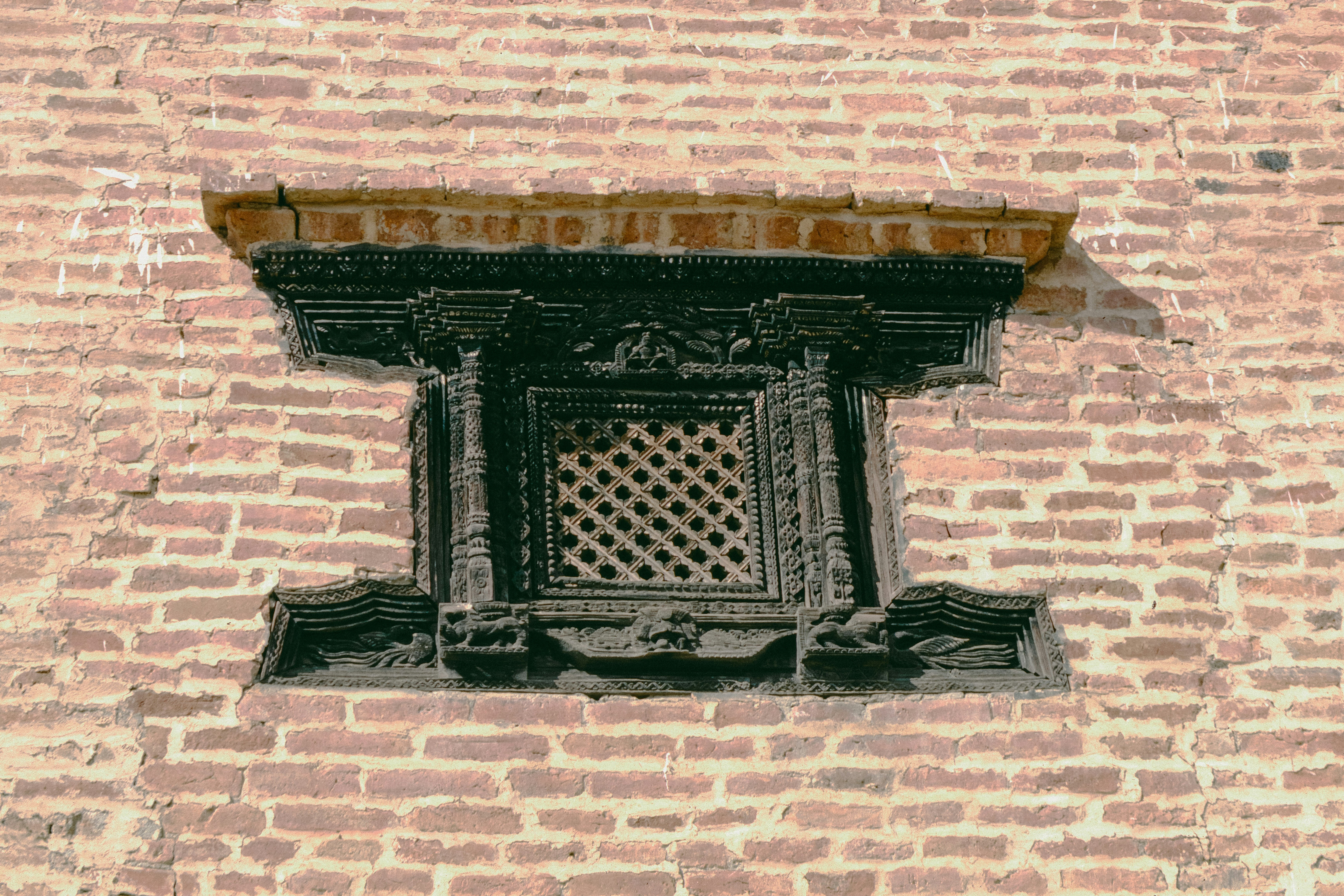 Ornate Window Niche in Weathered Brick Facade