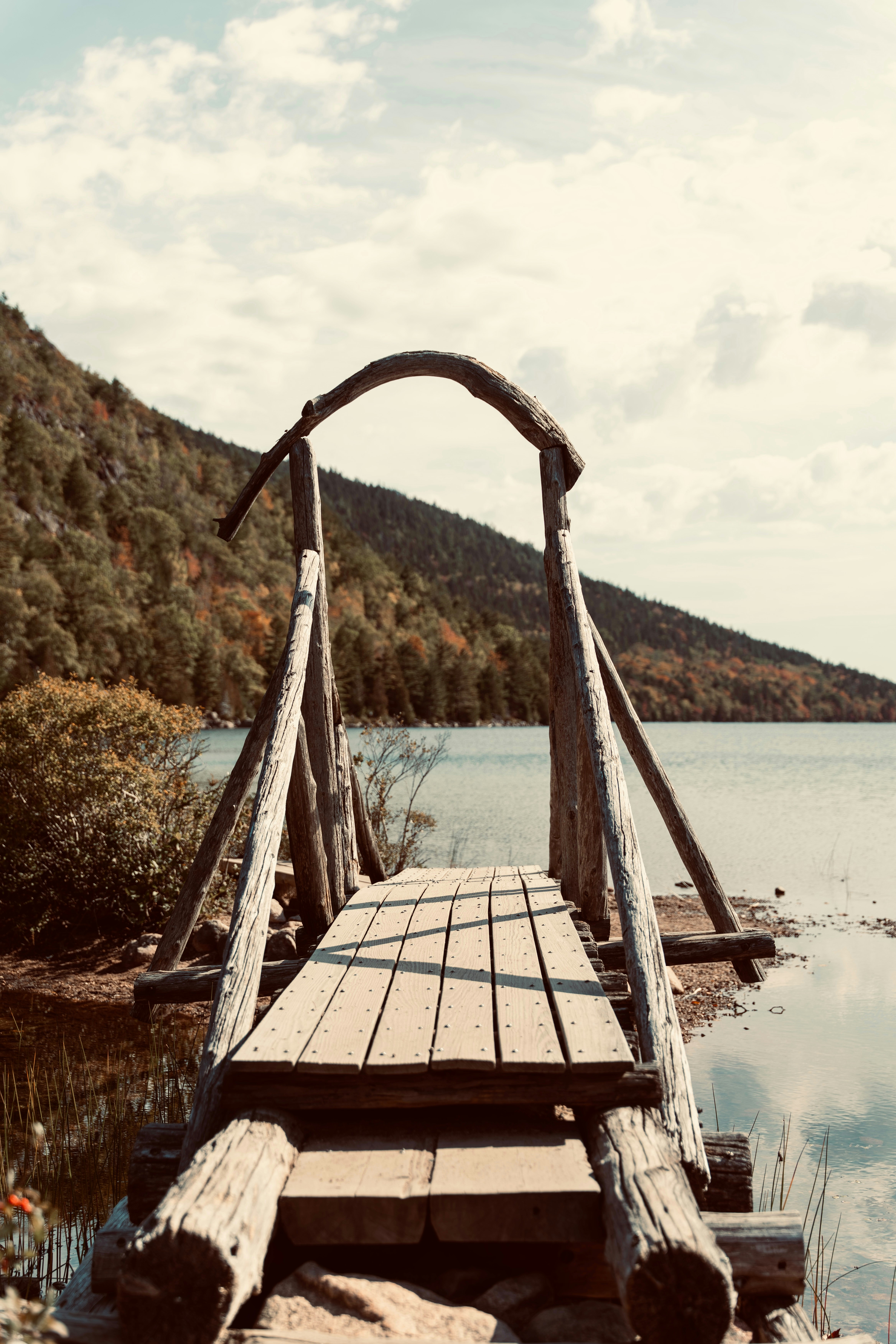 Wooden Arch Over a Quiet Lake: A Rustic Pier into Autumn Silence