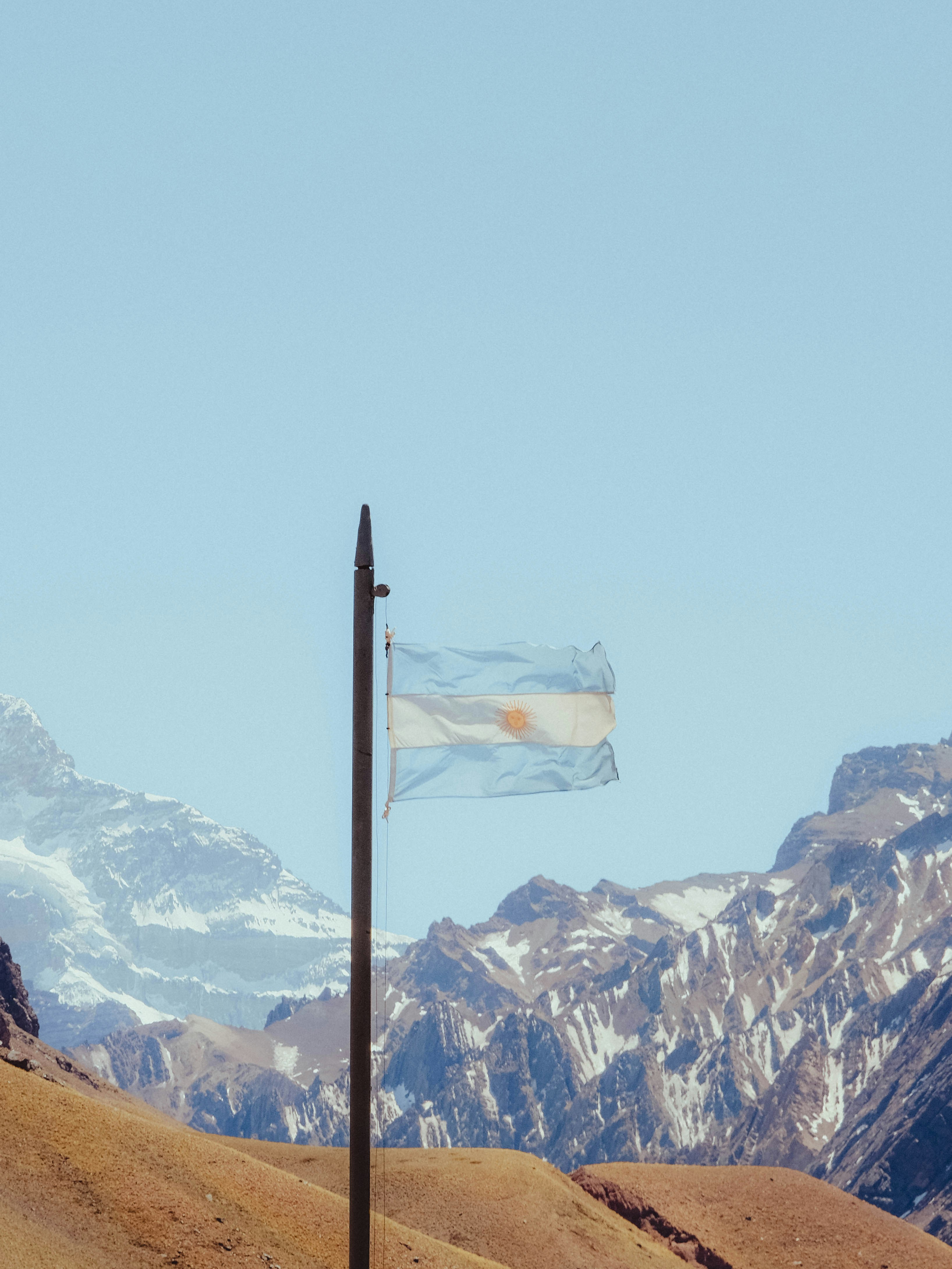 Pole and Flag above Rugged Andes