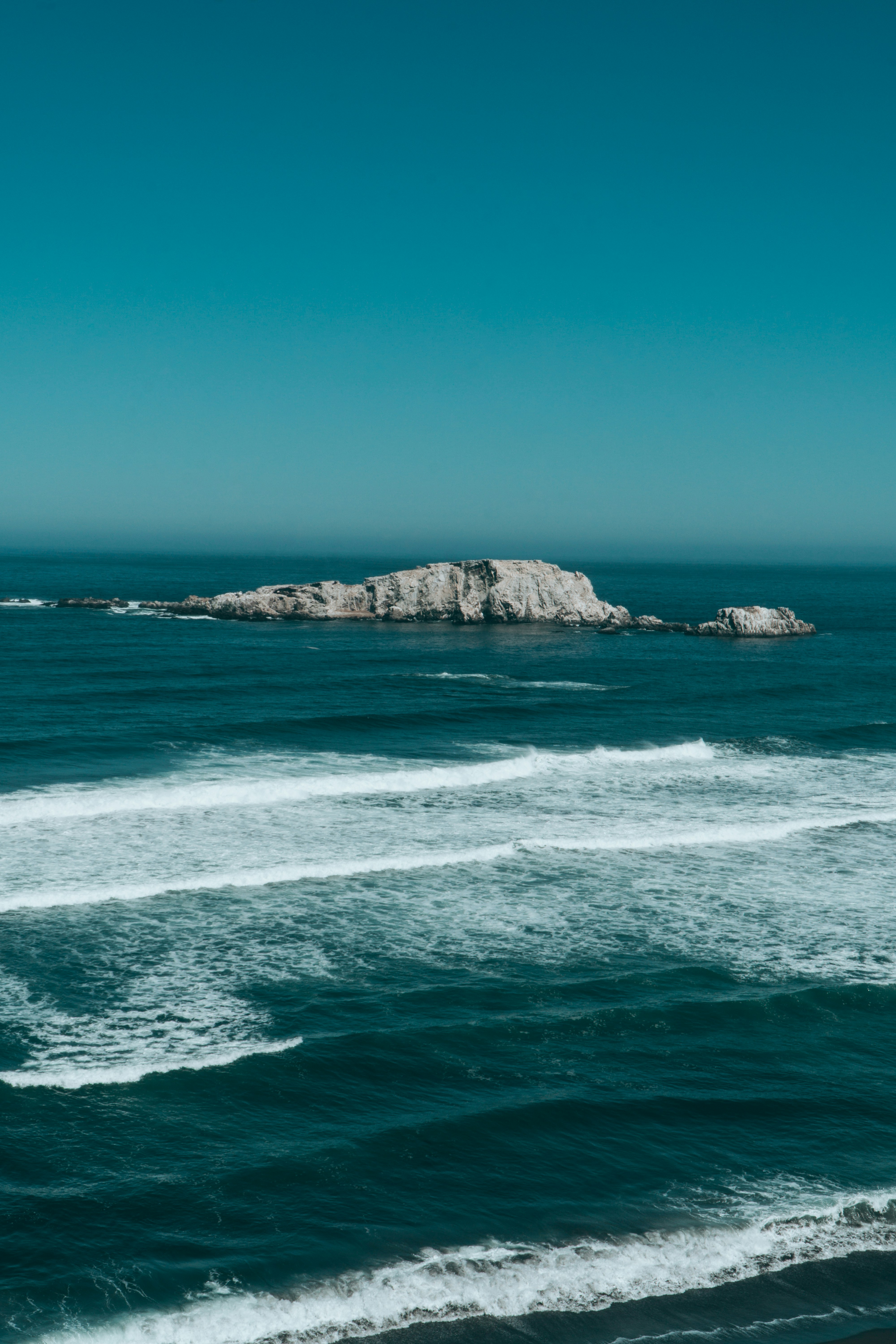 Teal Horizon Over Quiet Breakwaters