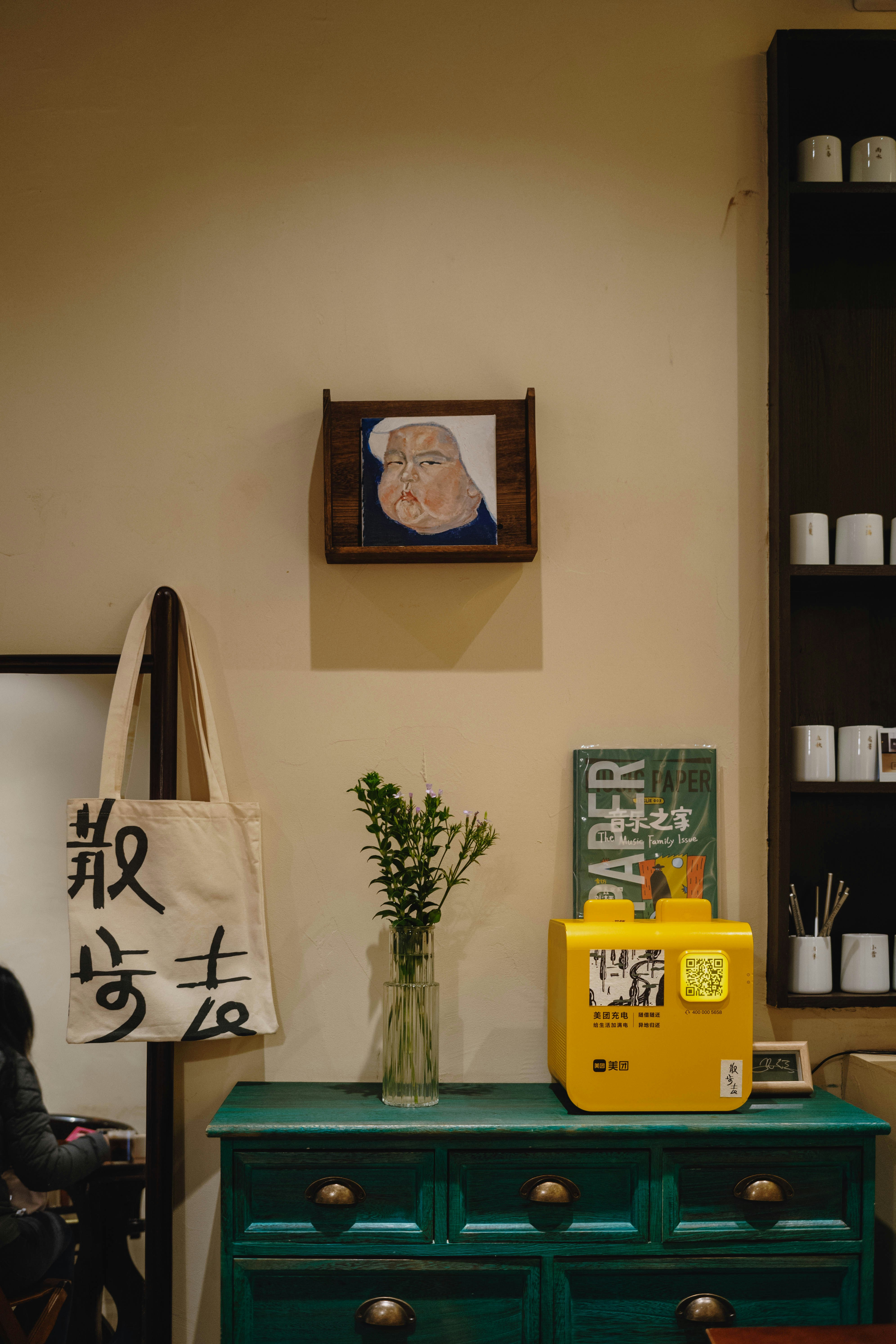 Portrait in a Café Corner: Framed Face Above a Teal Commode