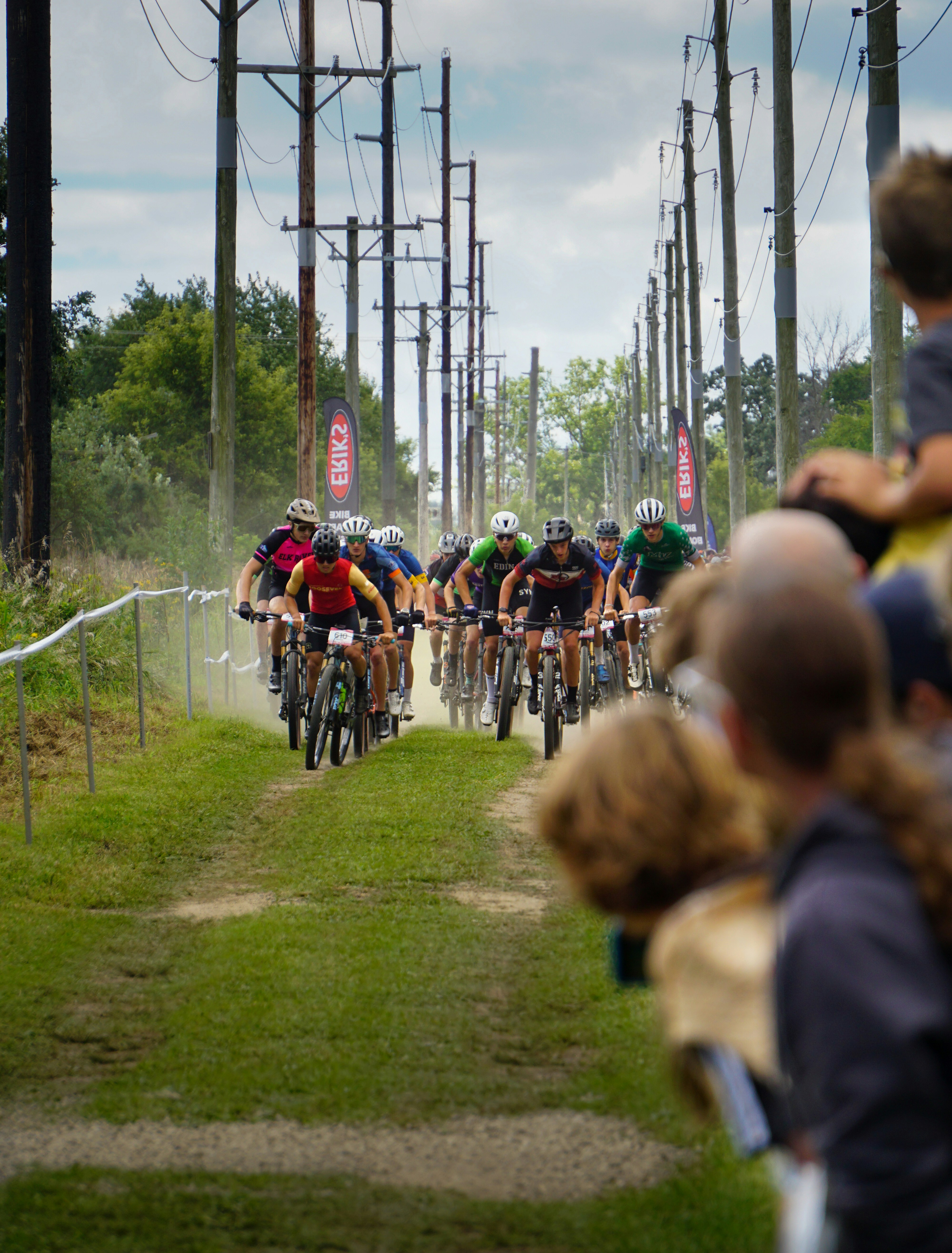 Midfield Sprint: Riders Punch Through a Rural Gate