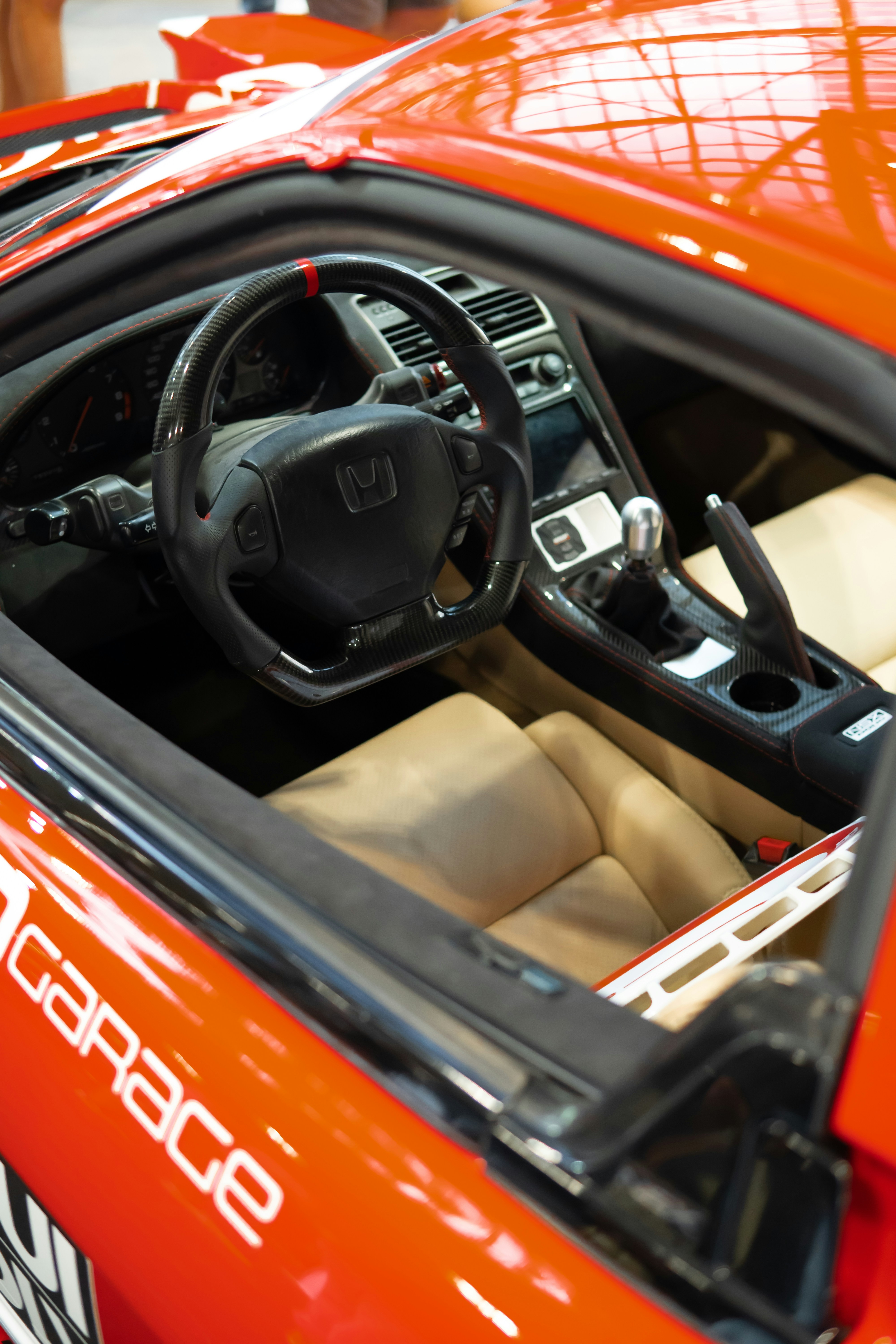 Red cockpit: close-up of the driver’s seat and steering in a bright race car interior