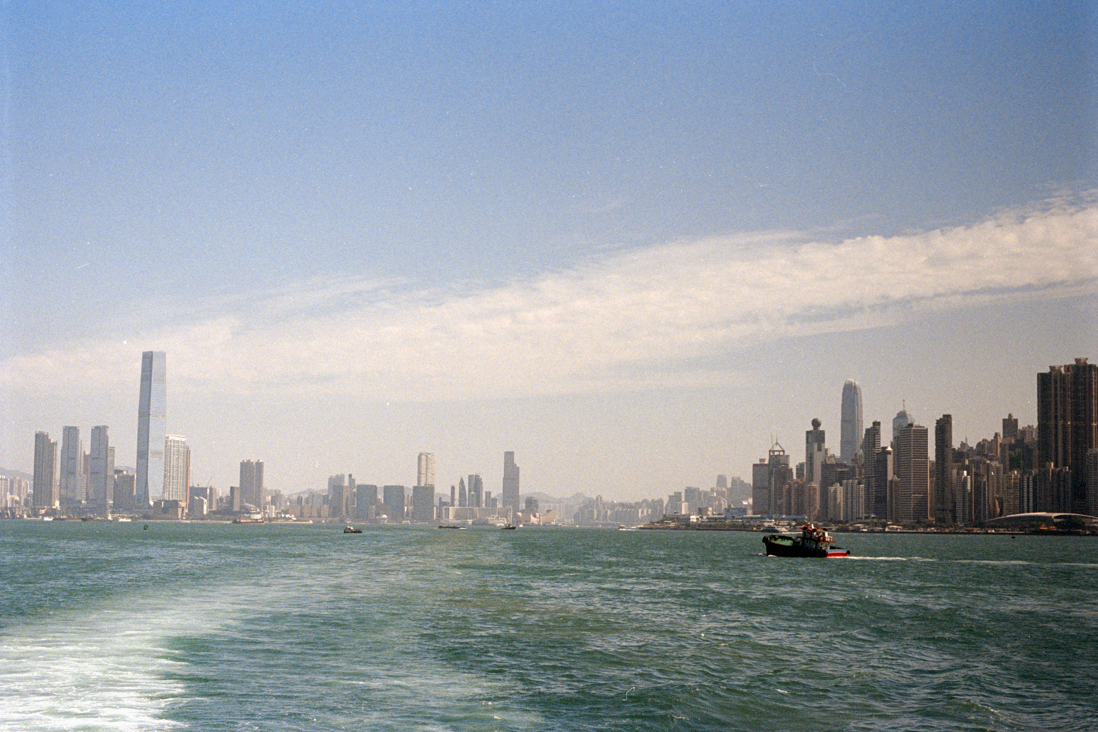 City skyline across the water with a small boat. photo – Free Travel ...