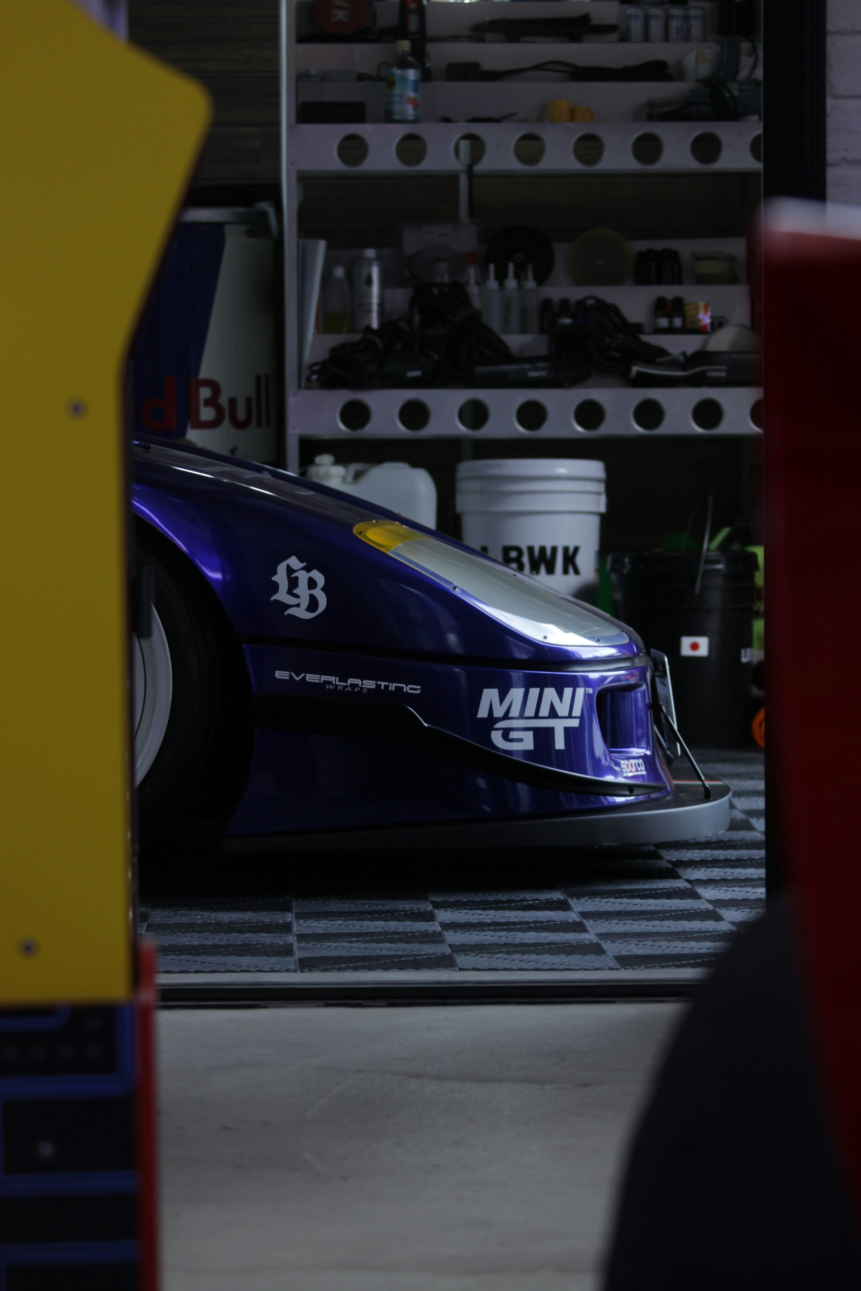 Purple racer in a dimly lit pit readying for the next lap
