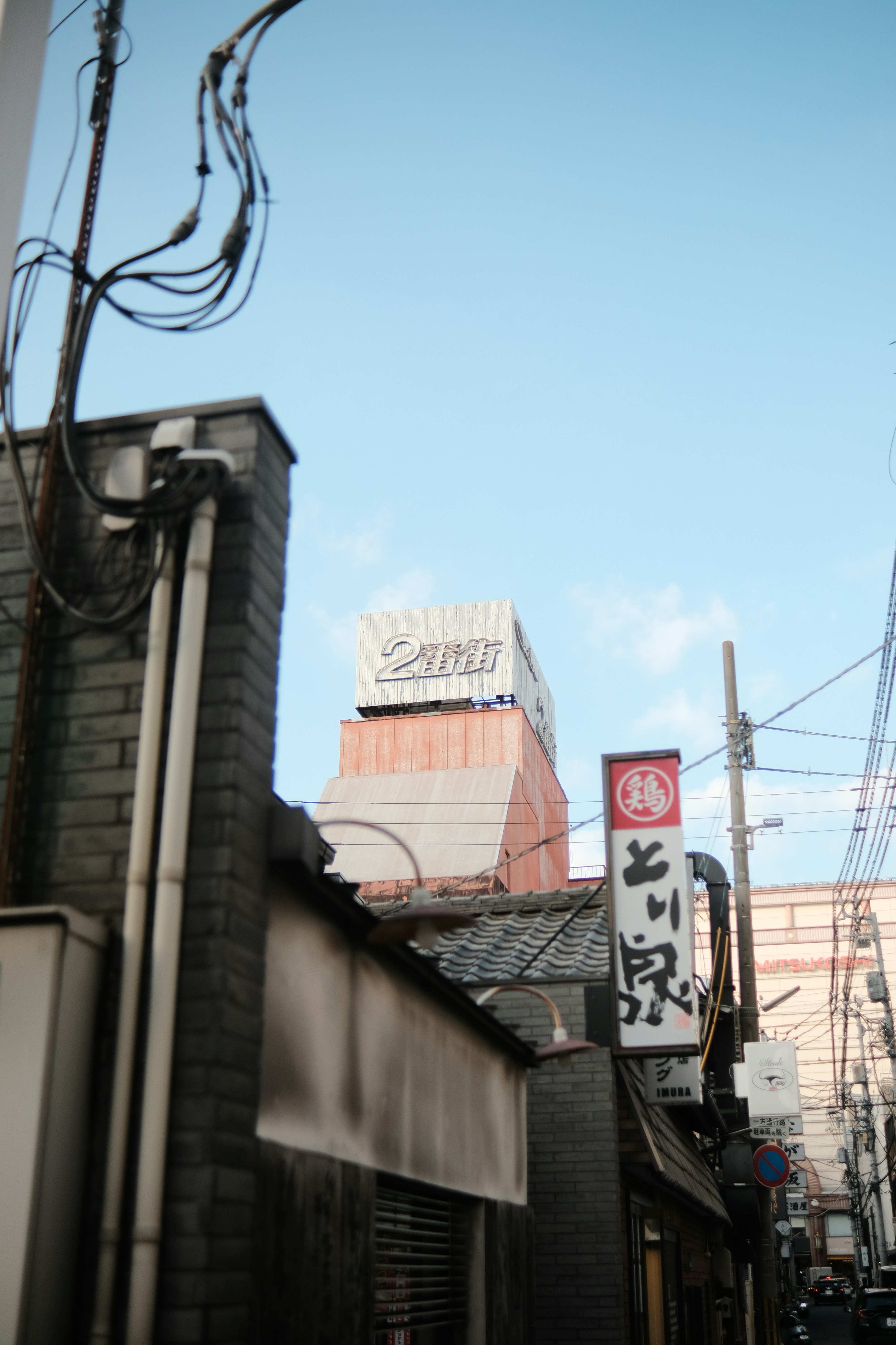 Narrow Japanese Arcades Under a Sky of Utility Wires