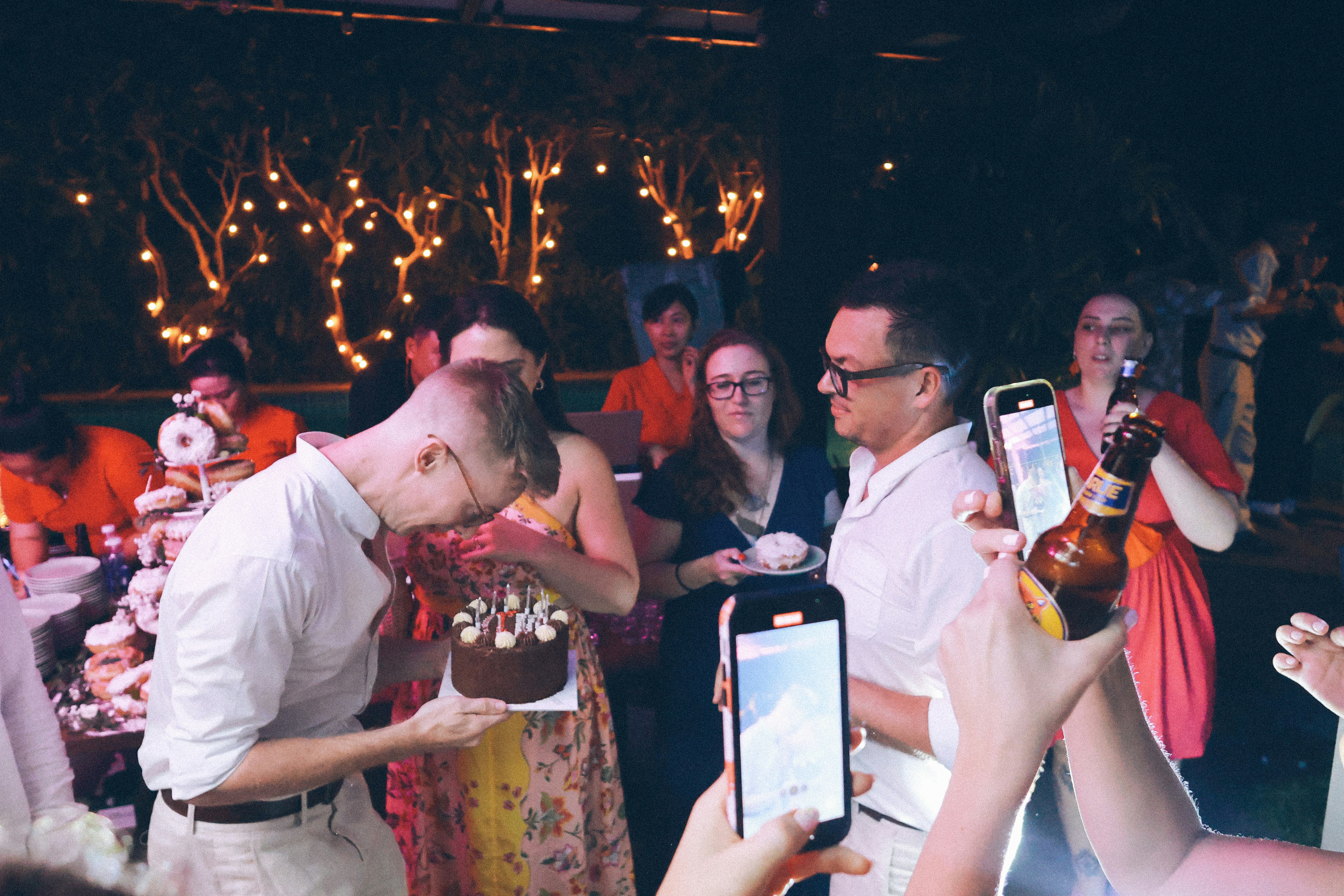Birthday Moment Under String Lights: Cheers and Confetti