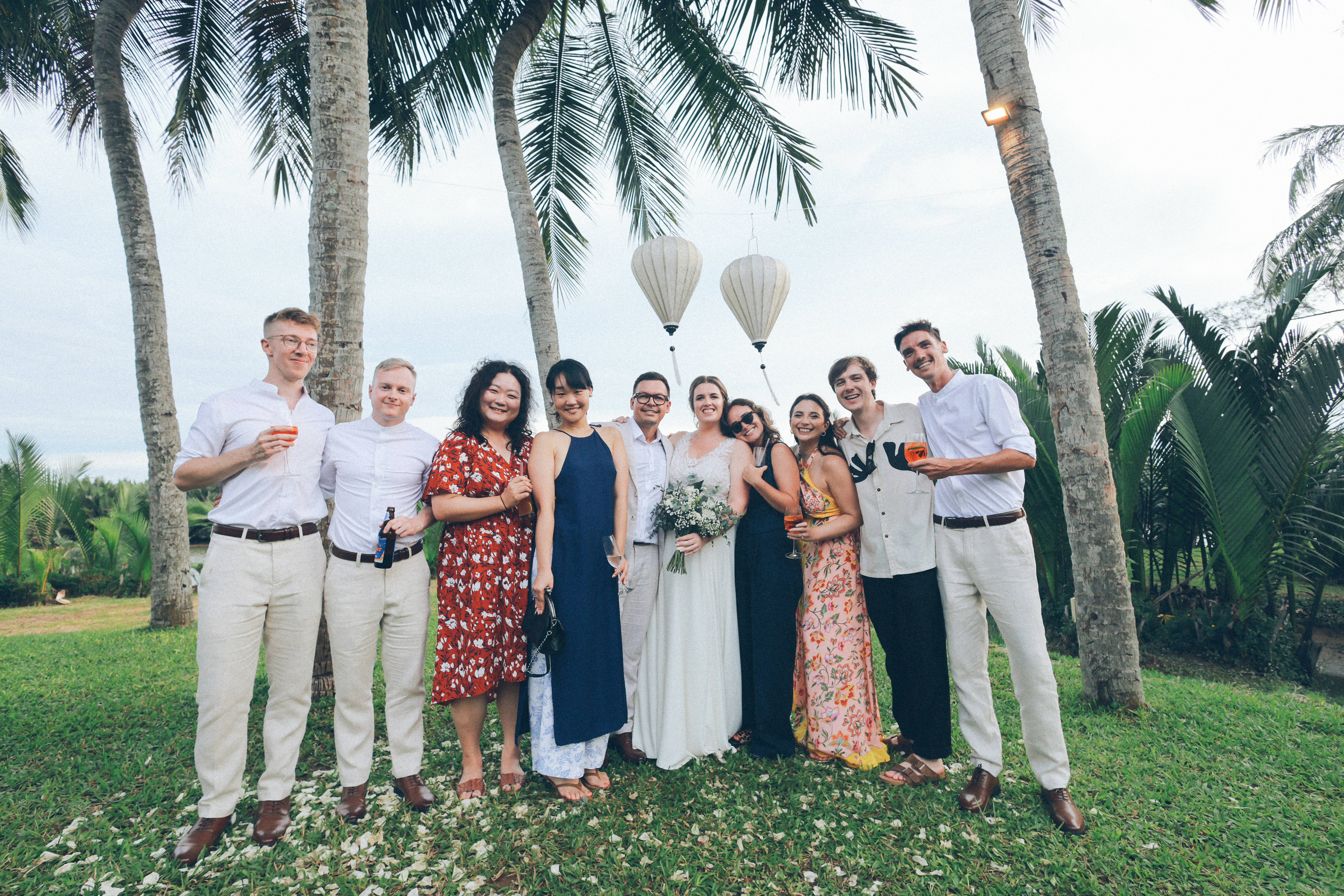 Wedding Party Under Palms: A Sunny Group Shot on Lush Greens