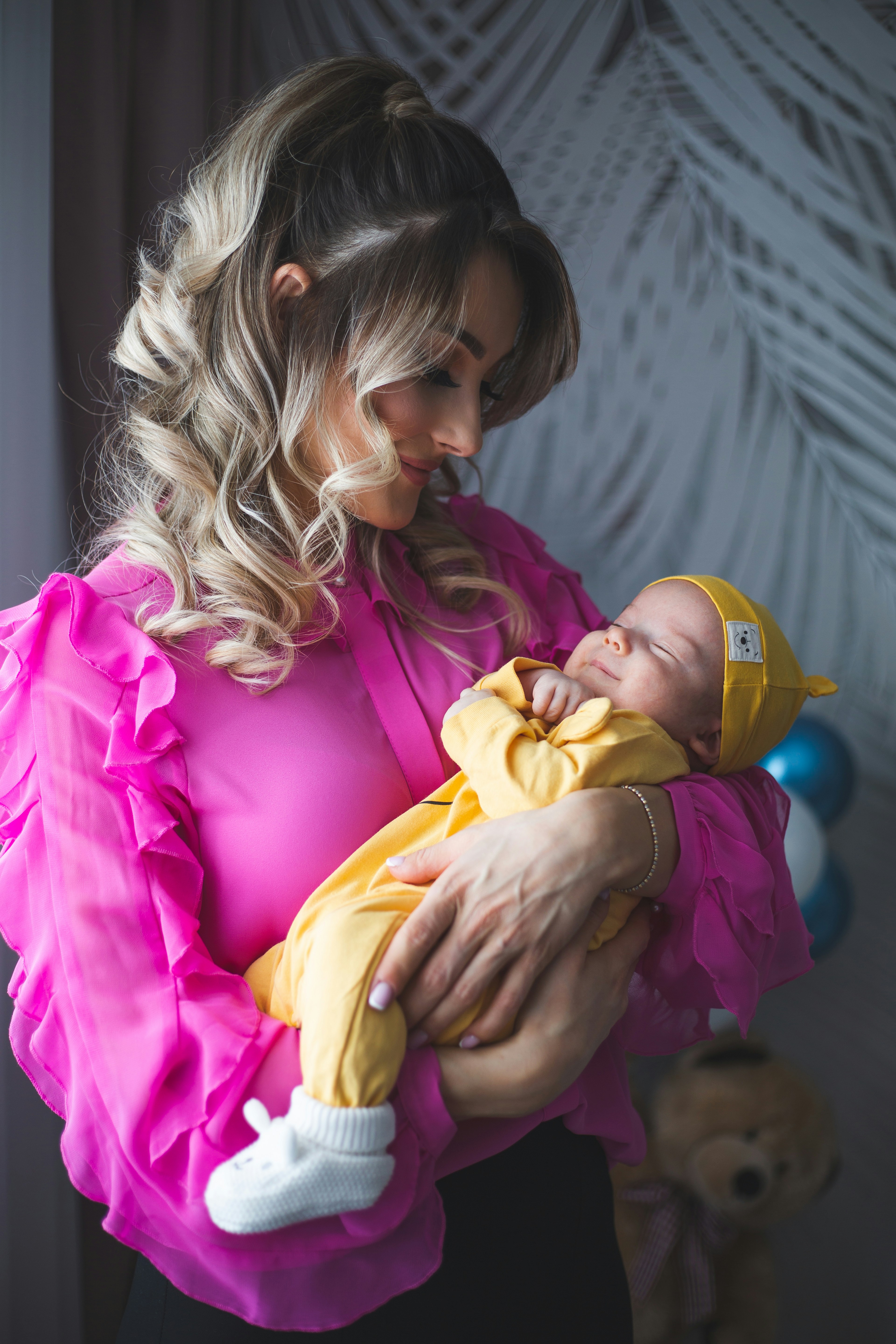 Mother holding her newborn baby in yellow outfit photo – Free Color ...