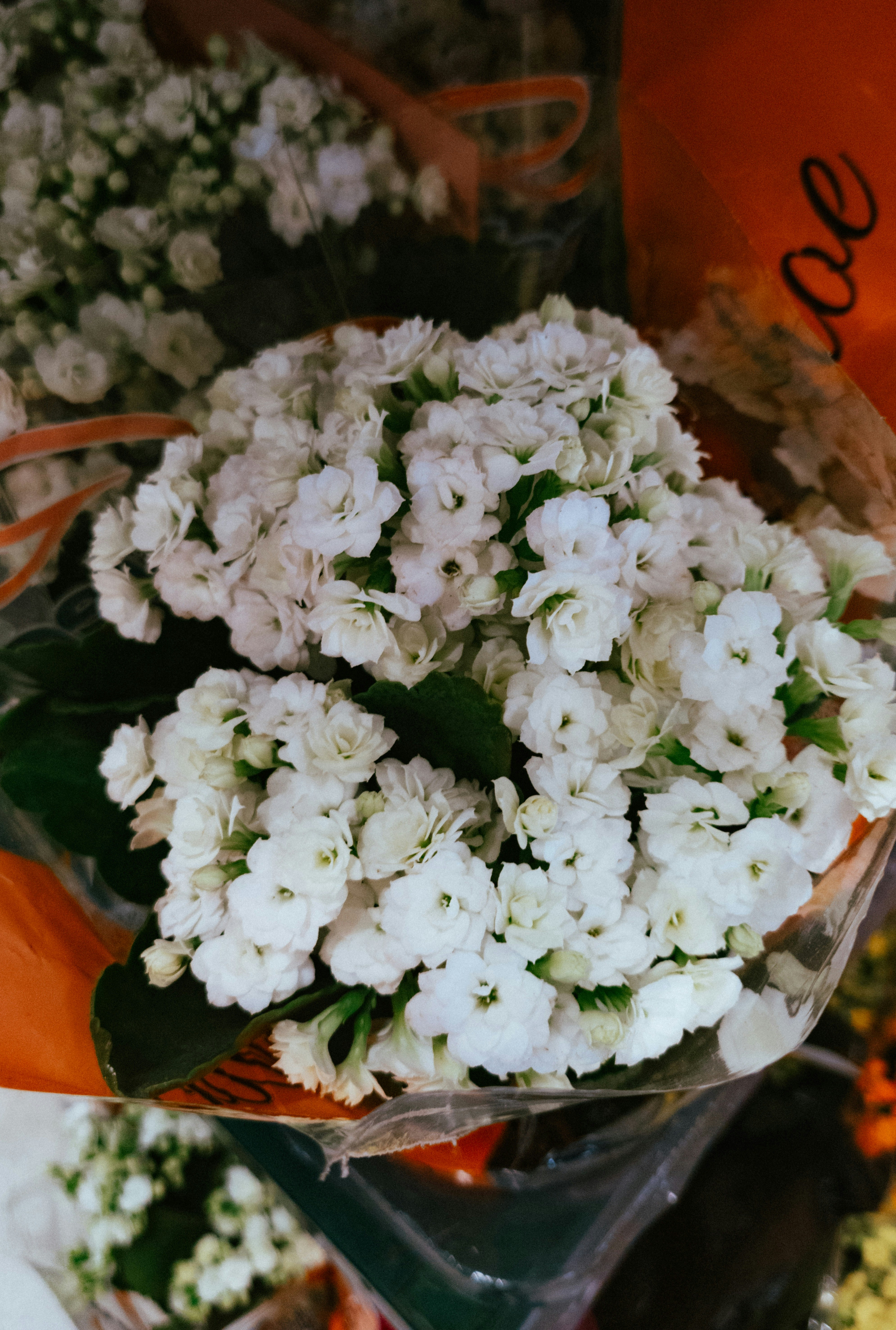 White Blossom Bouquet Wrapped in Orange Tabletide Packaging