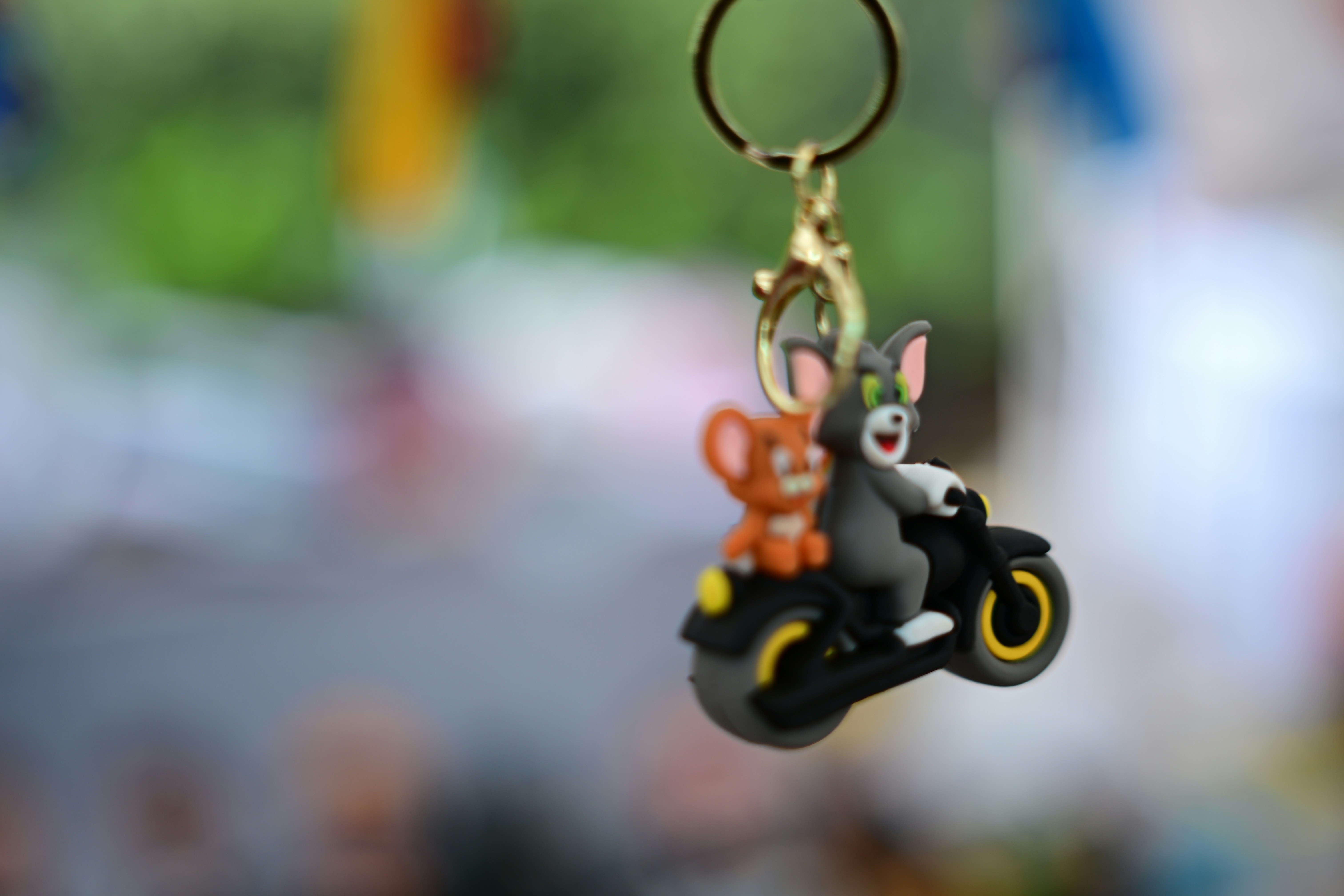 Tiny Riders on a Loop: Keychain Charms in a Blurred Backdrop