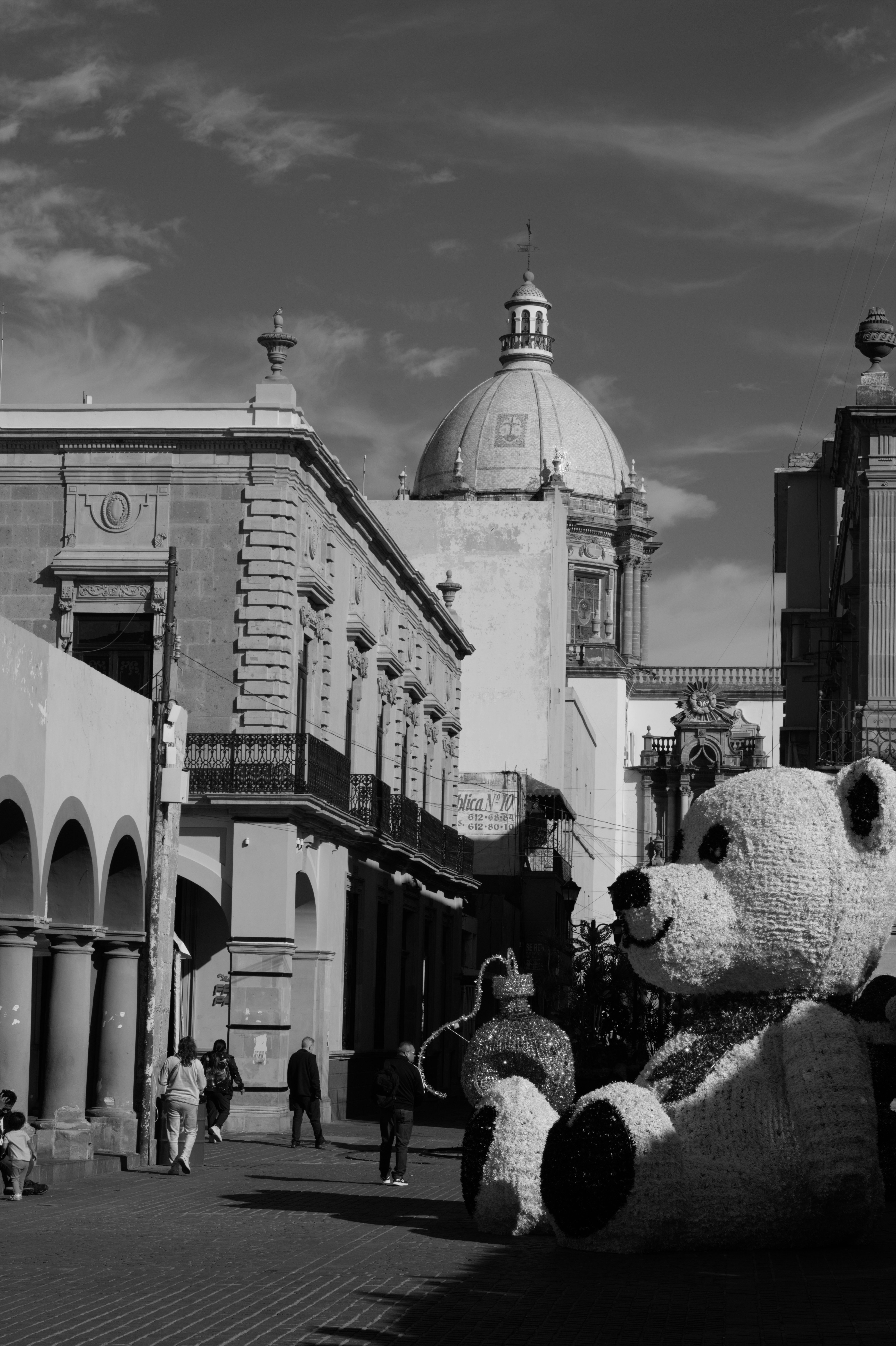 Floating Bear and Historic Facades: A Black-and-White Street Scene