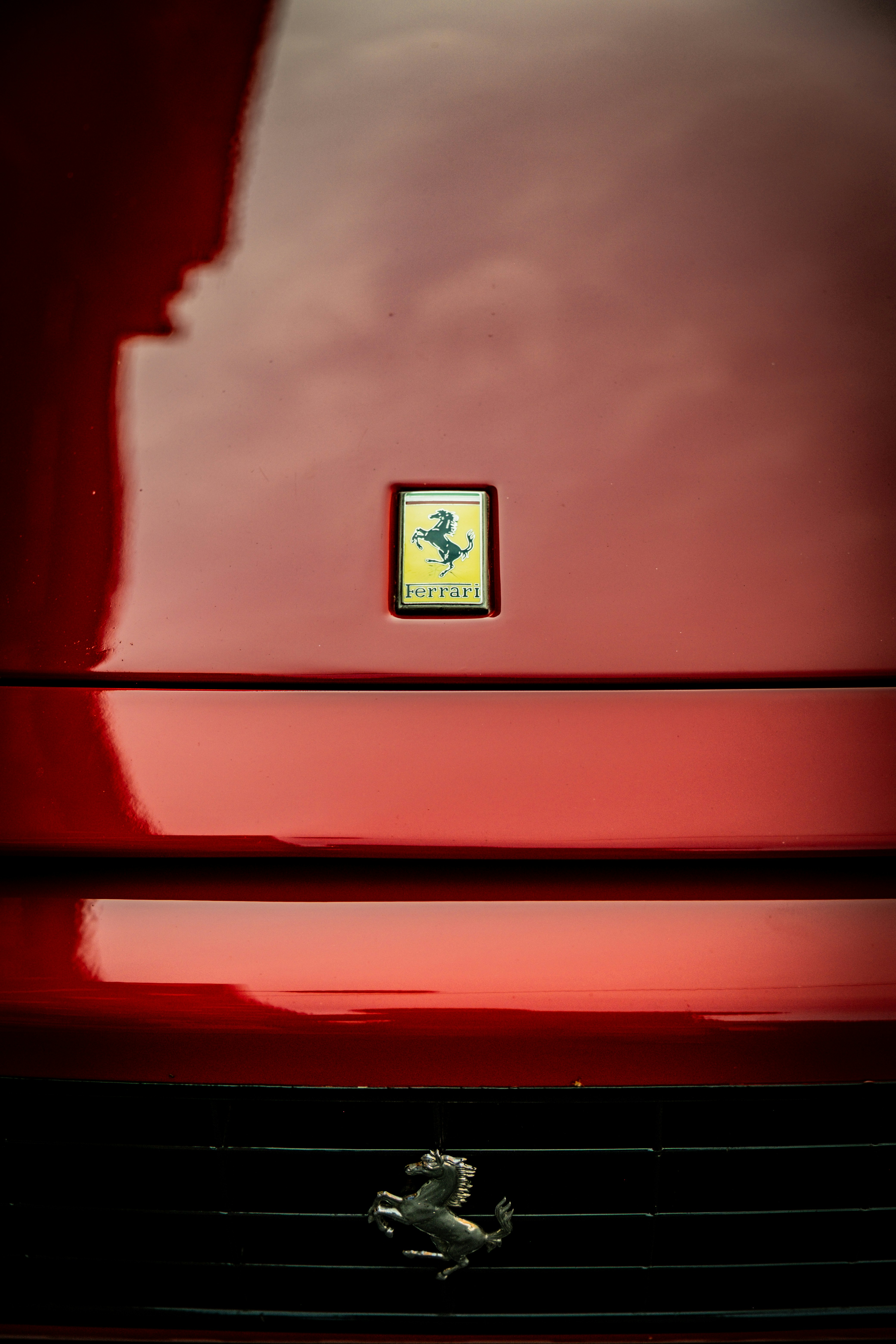 Red Icon, Dark Stall: Ferrari Emblem on a Gleaming Hood