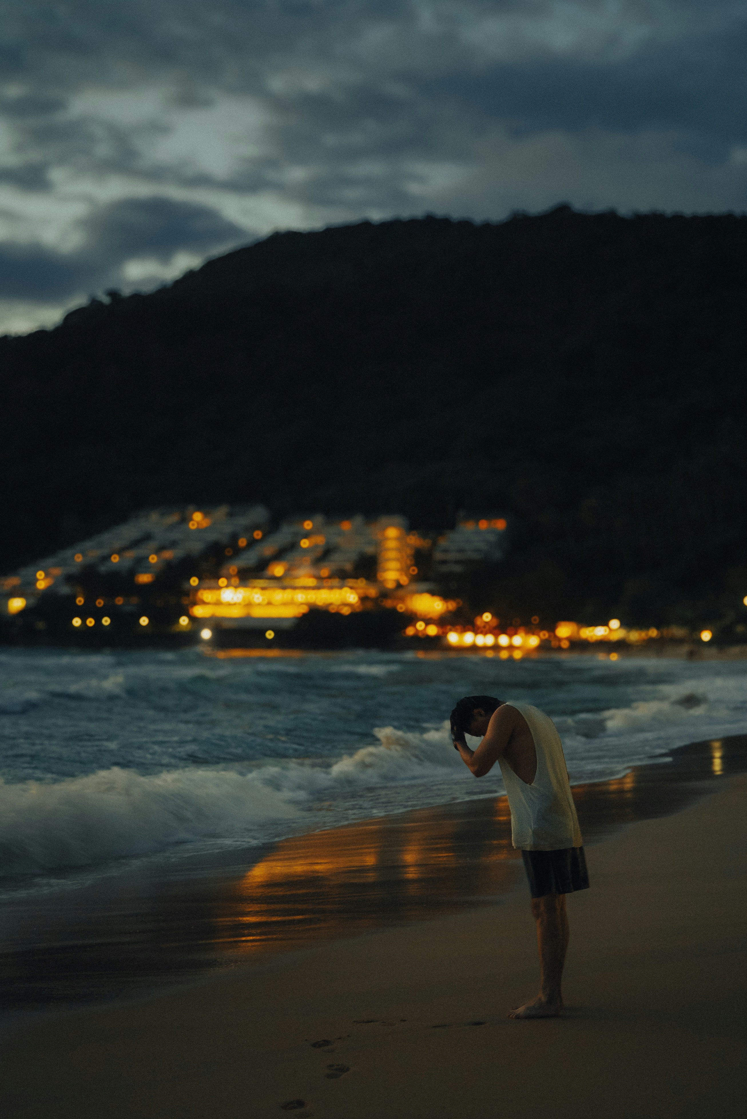 Belled at the Shore: A lone figure beneath a coastal moonlit glow