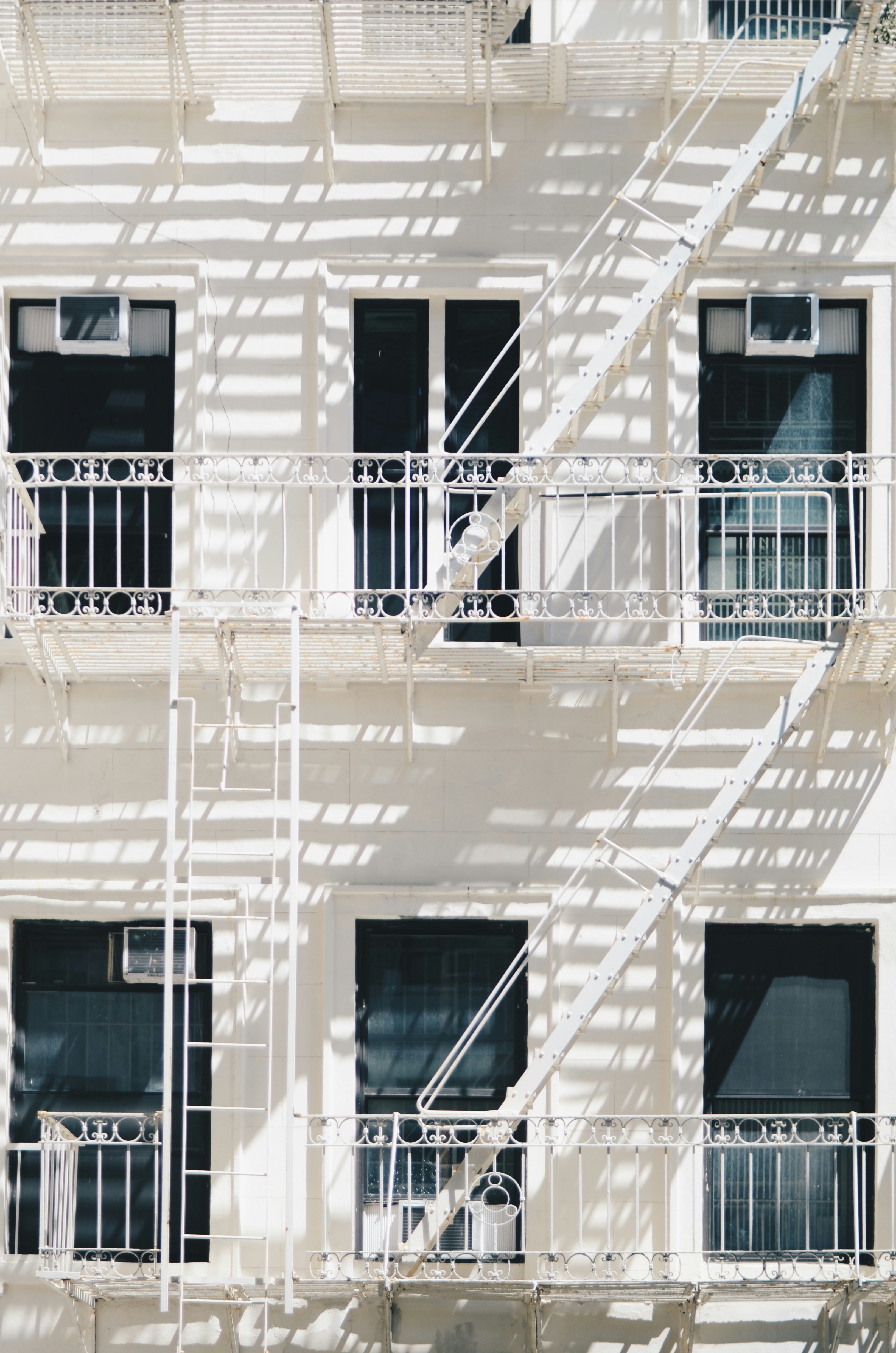 White building facade with windows and fire escape photo – Free ...