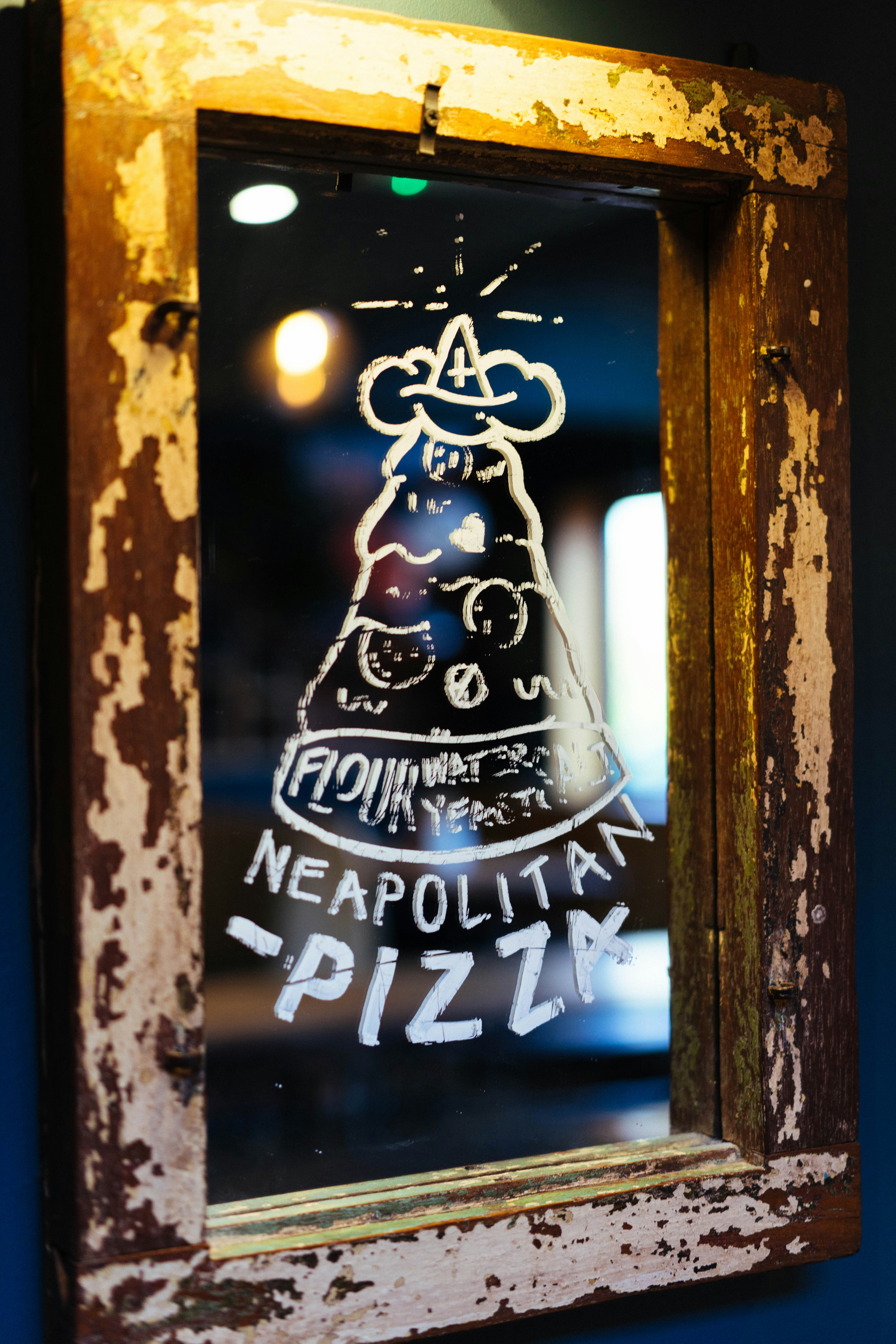 Glass-panel Graffiti: A Weathered Frame Framing a Pizzeria Sketch