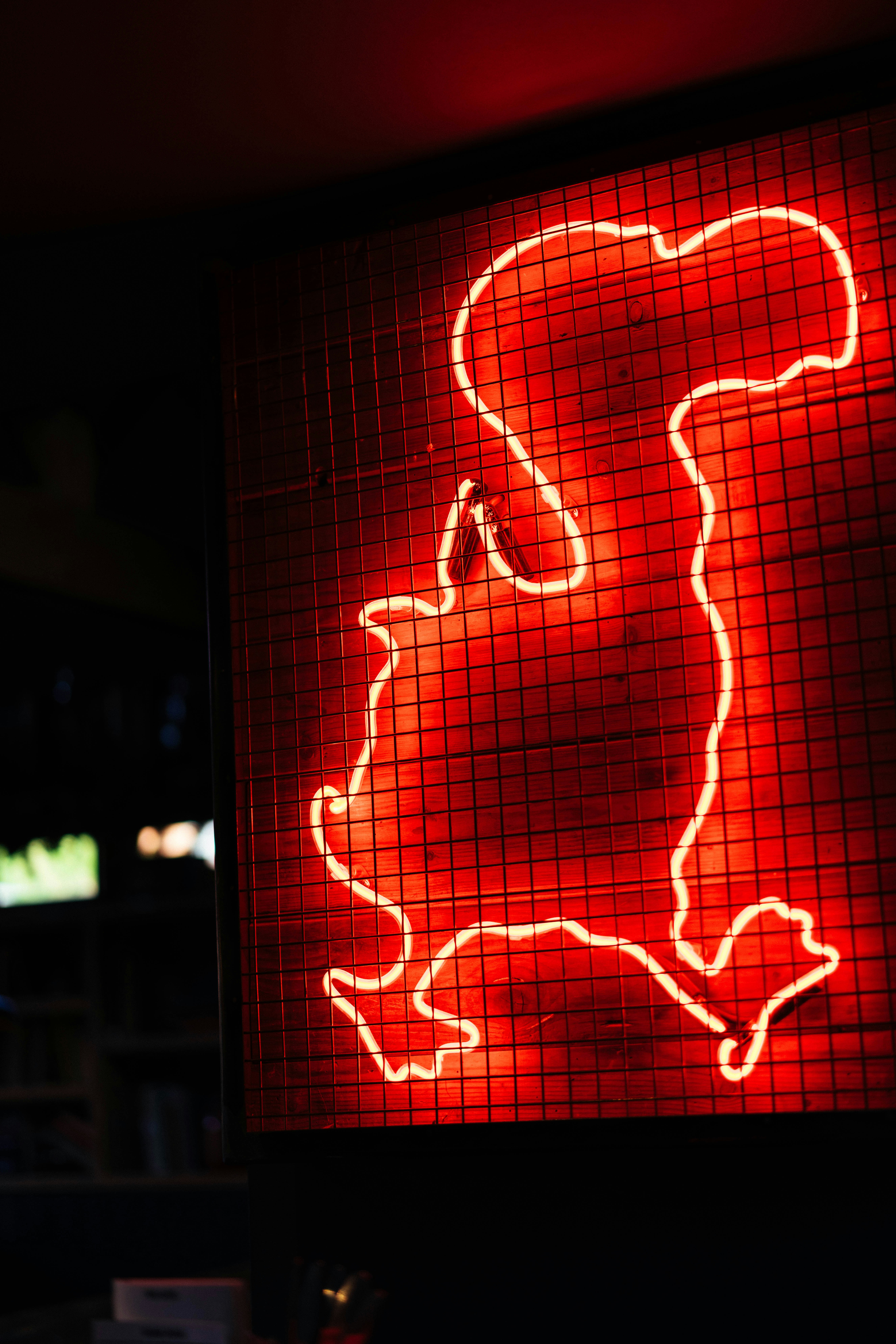 Neon Outline of a Figure Casting Warm Red Glow in a Dark Room