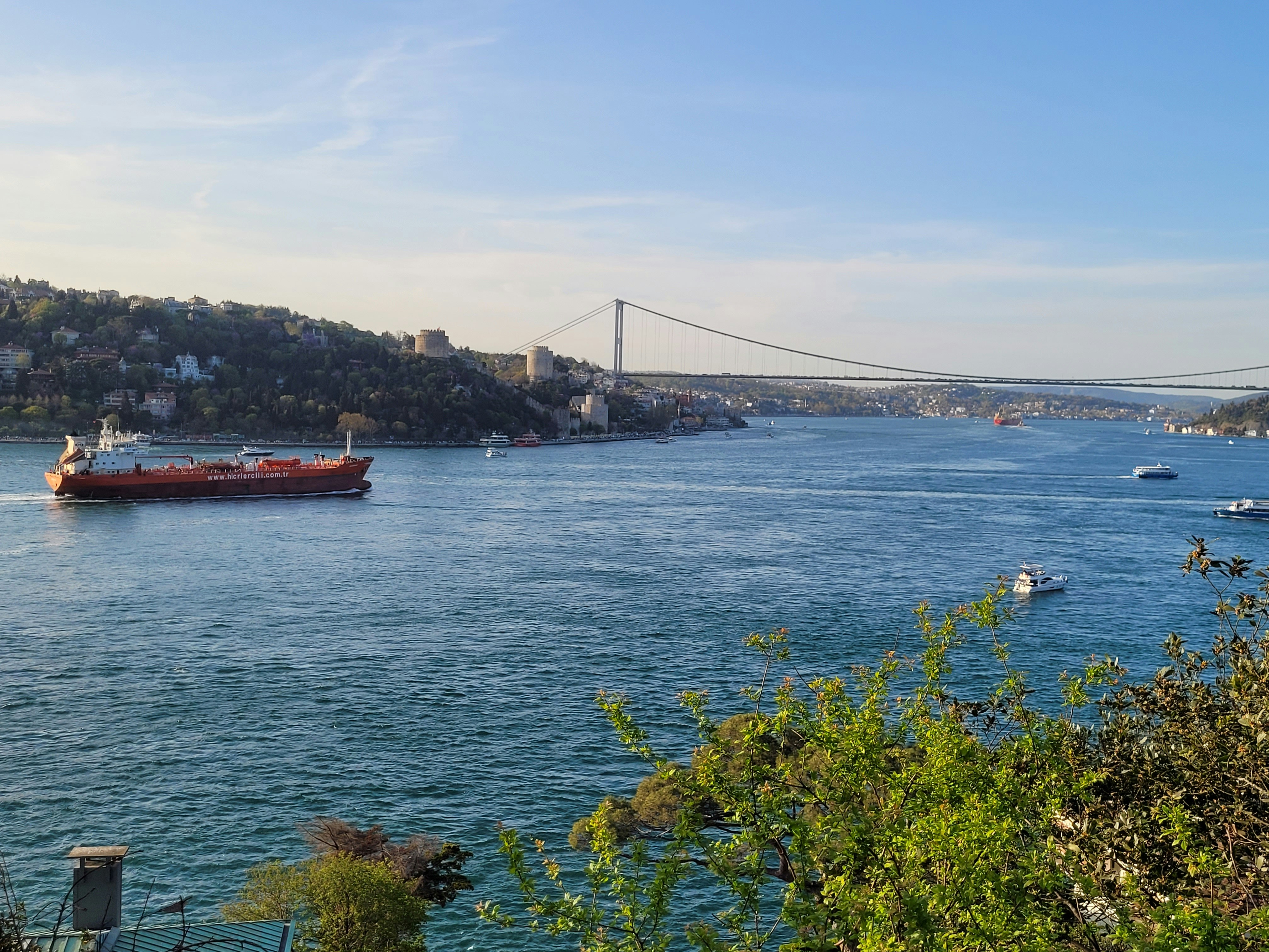 Vast blue harbor under a distant suspension bridge