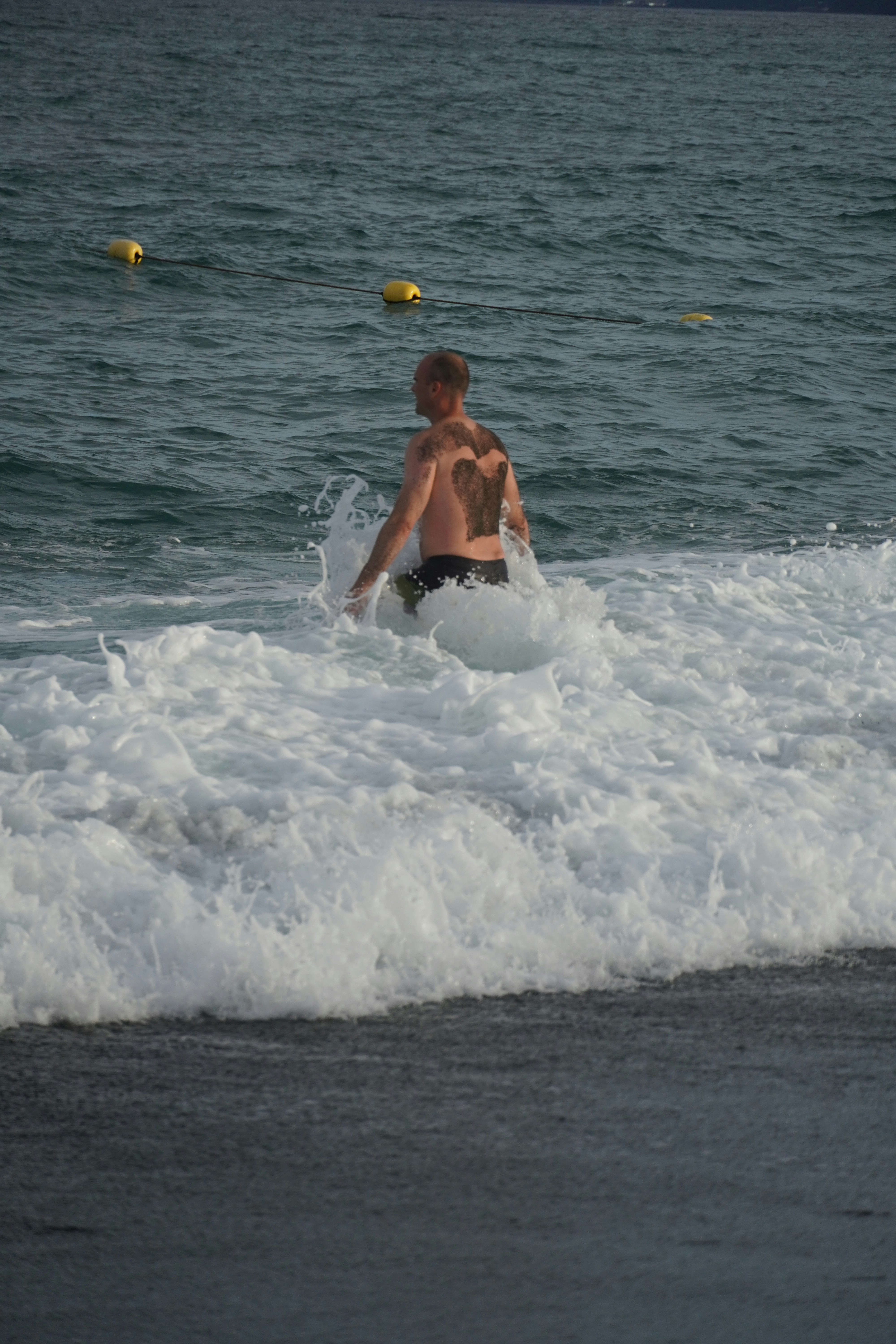 Surfer in Aerial White: A Solo Figure Confronts the Break