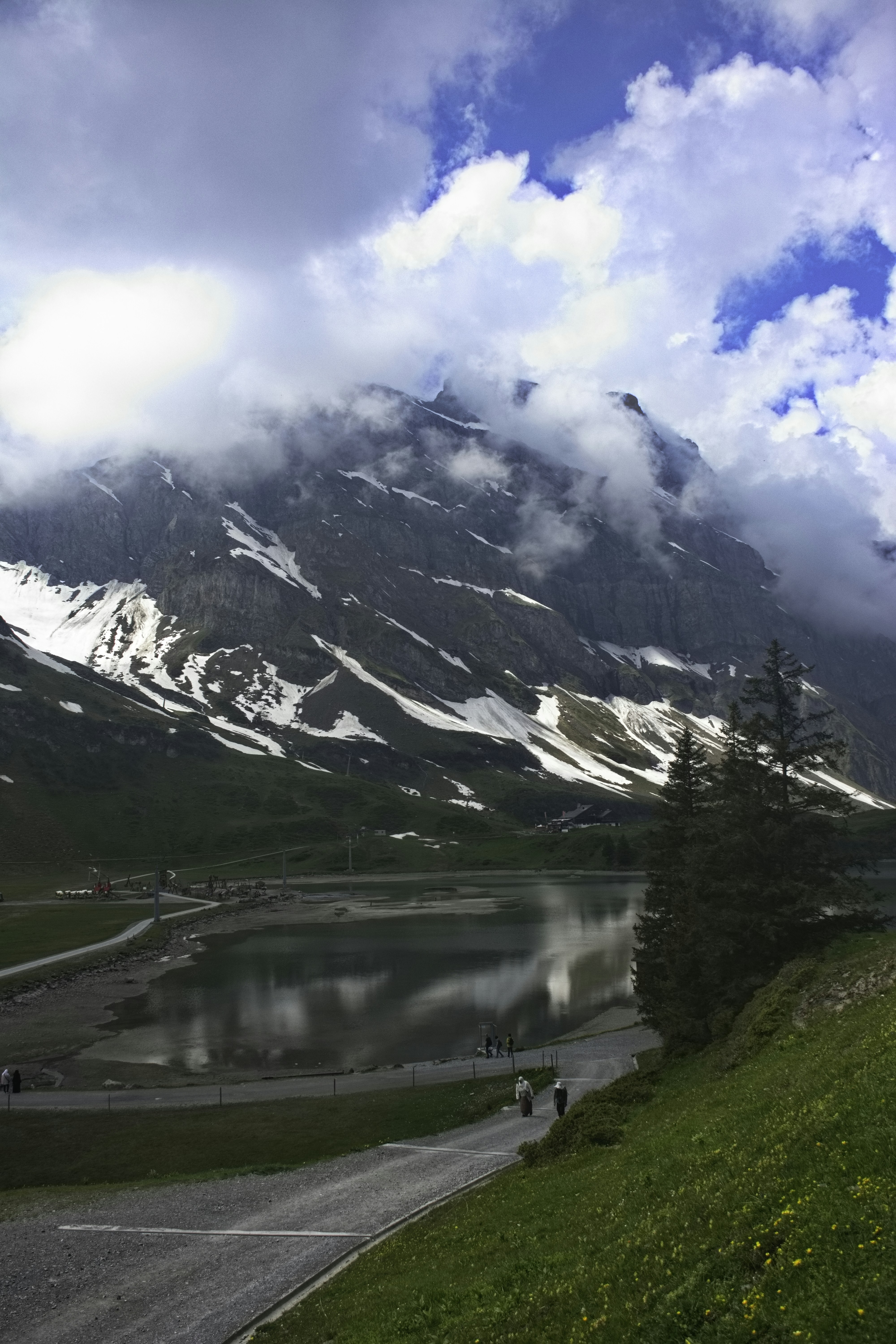 Clouds Over Snow-Capped Peaks by a Serene Alpine Lake