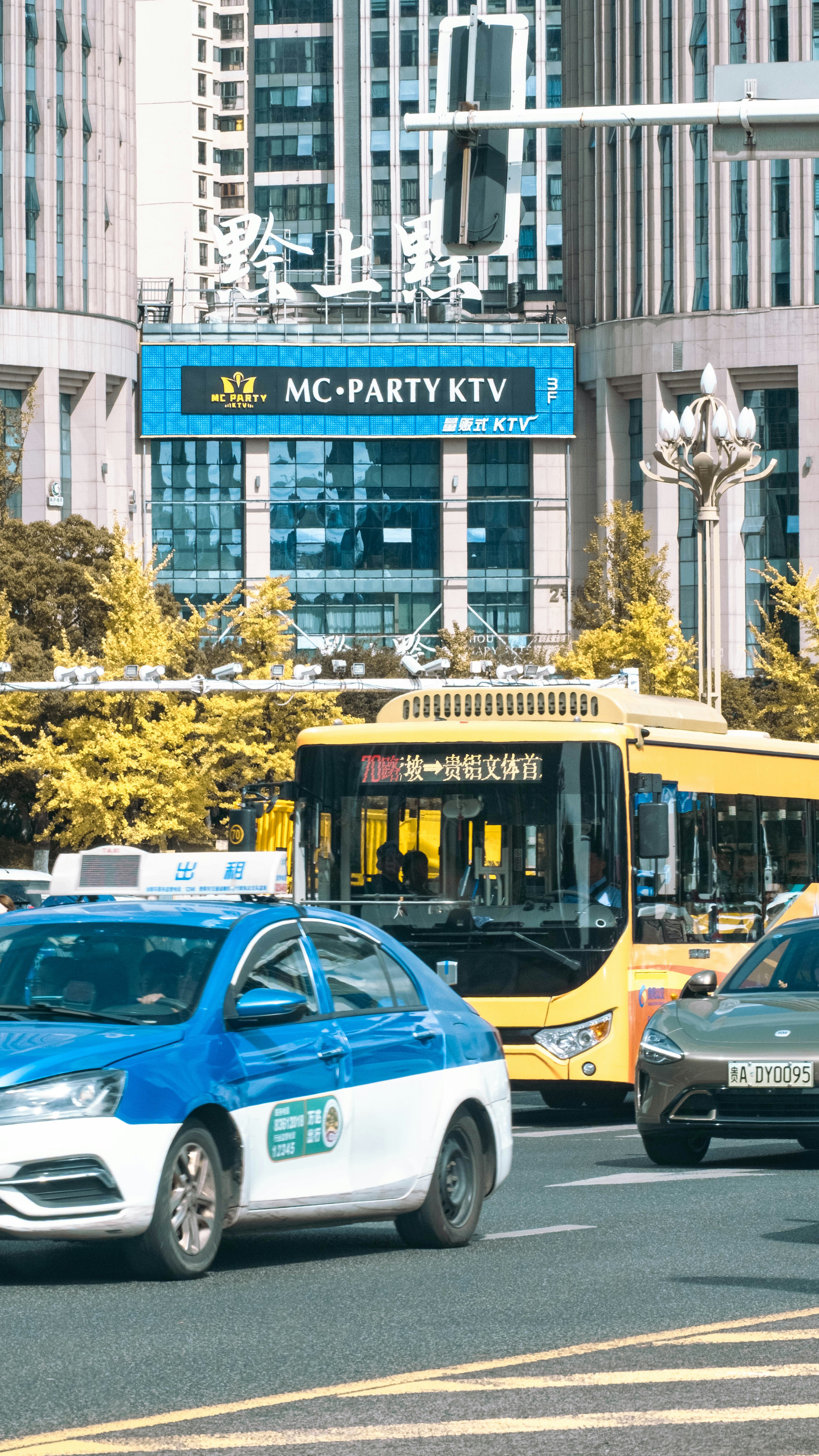 City Pulse: Yellow Bus, Blue Taxi, and Glass Skyline