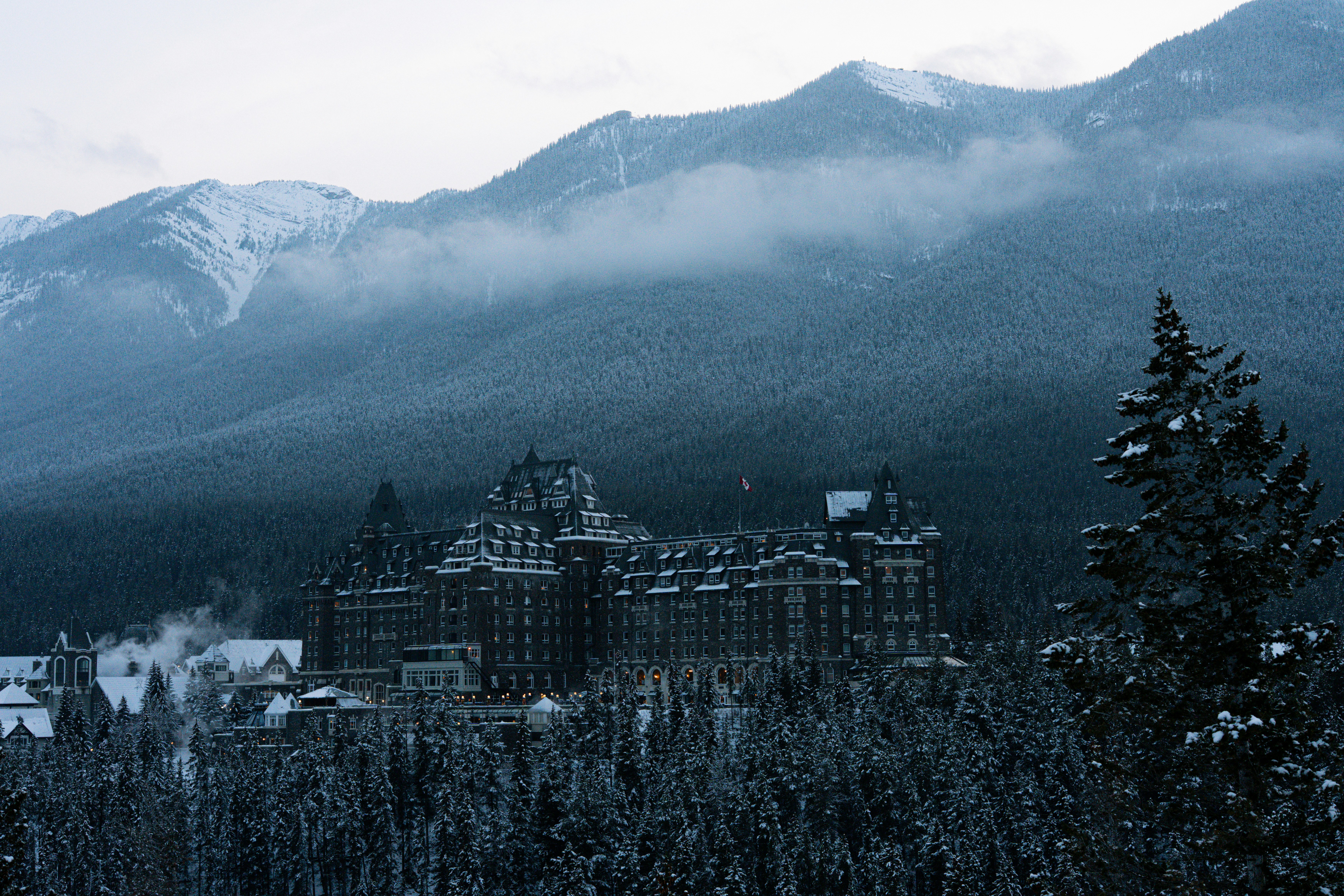 Castle in a Winter Quiet: Snow-Cloaked Peaks Rise Behind a Historic Lodge