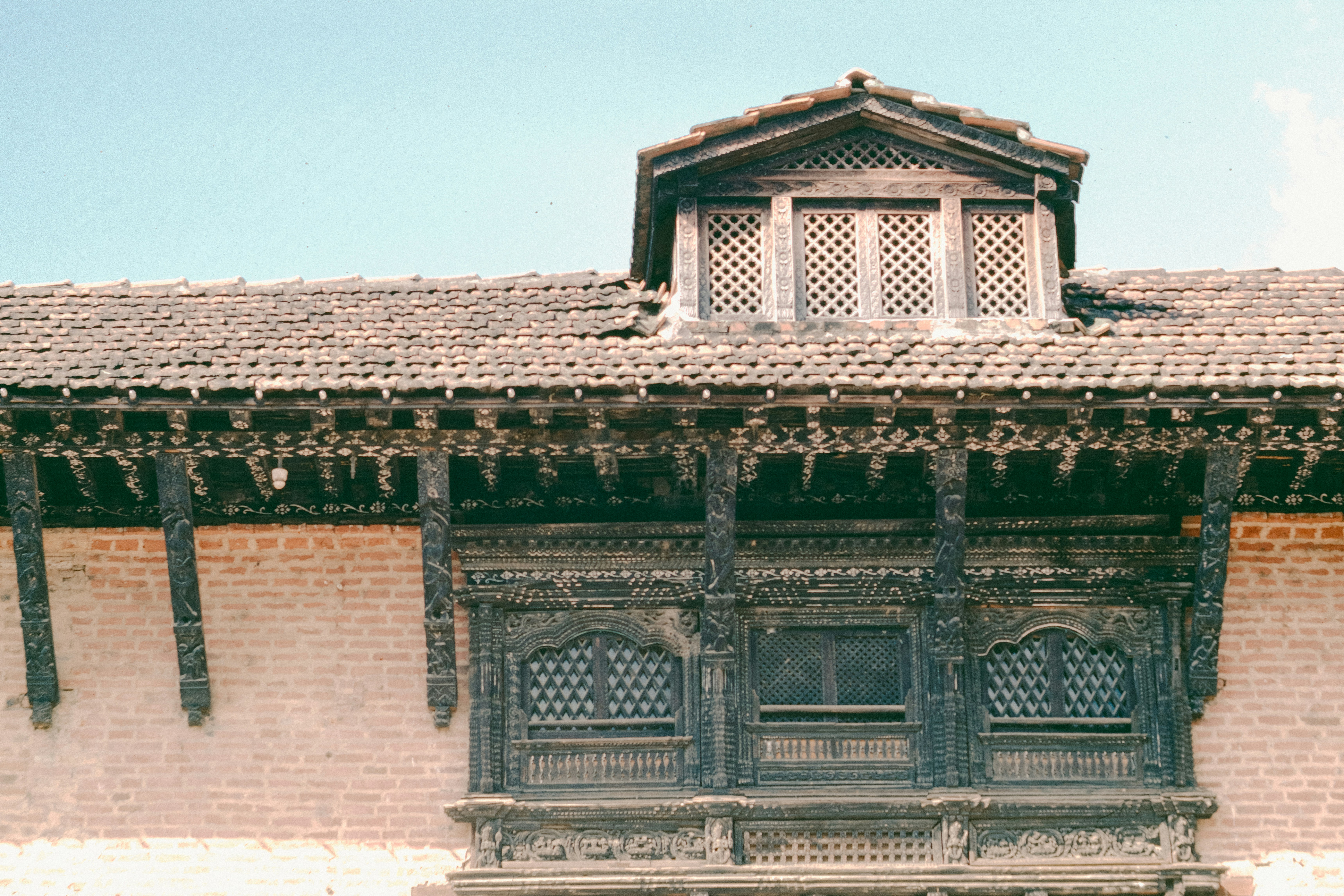 Intricately carved wooden window on a brick building. photo – Free ...