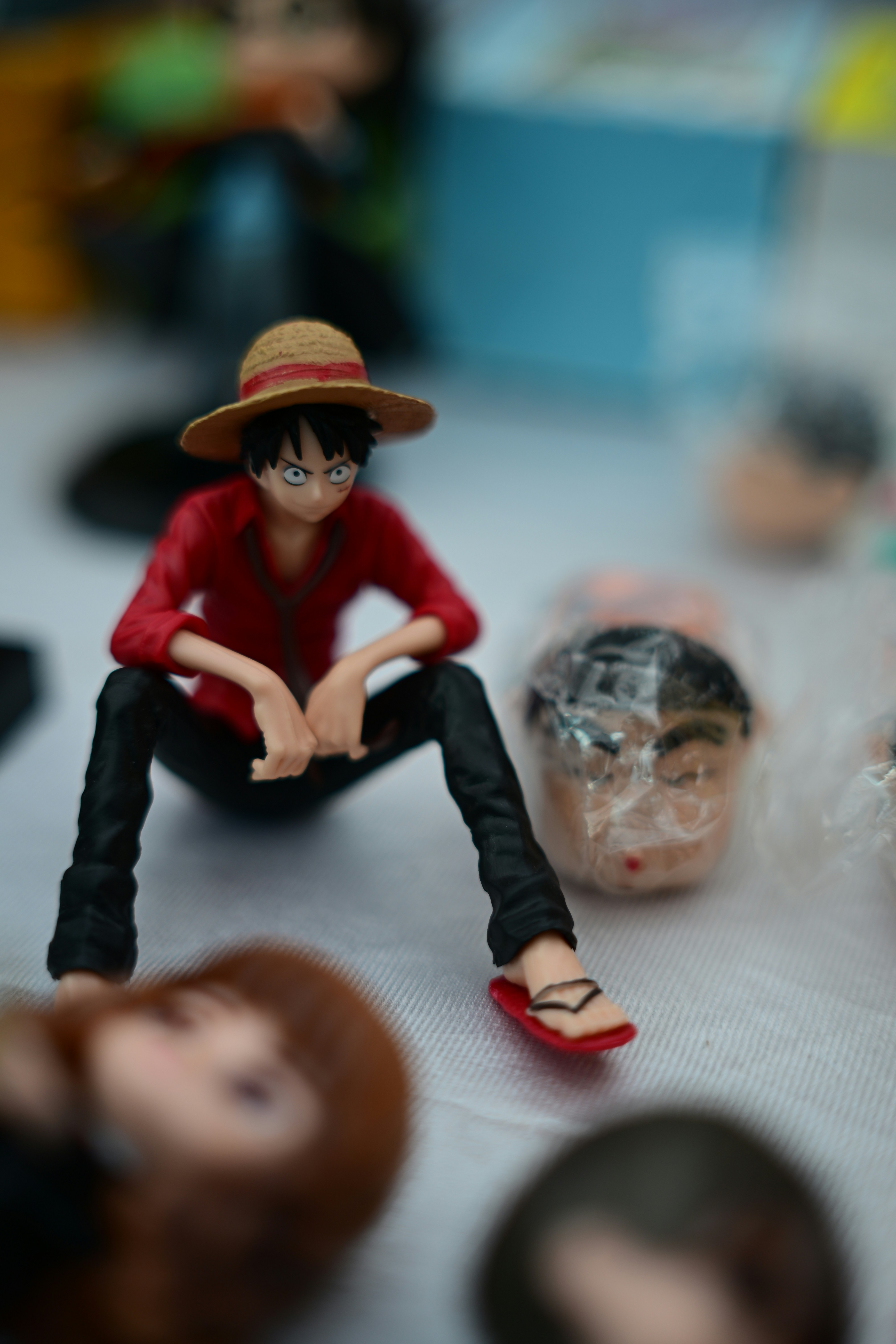 Luffy on a Quiet Desk: A Playful Standoff Amid Tiny Heads