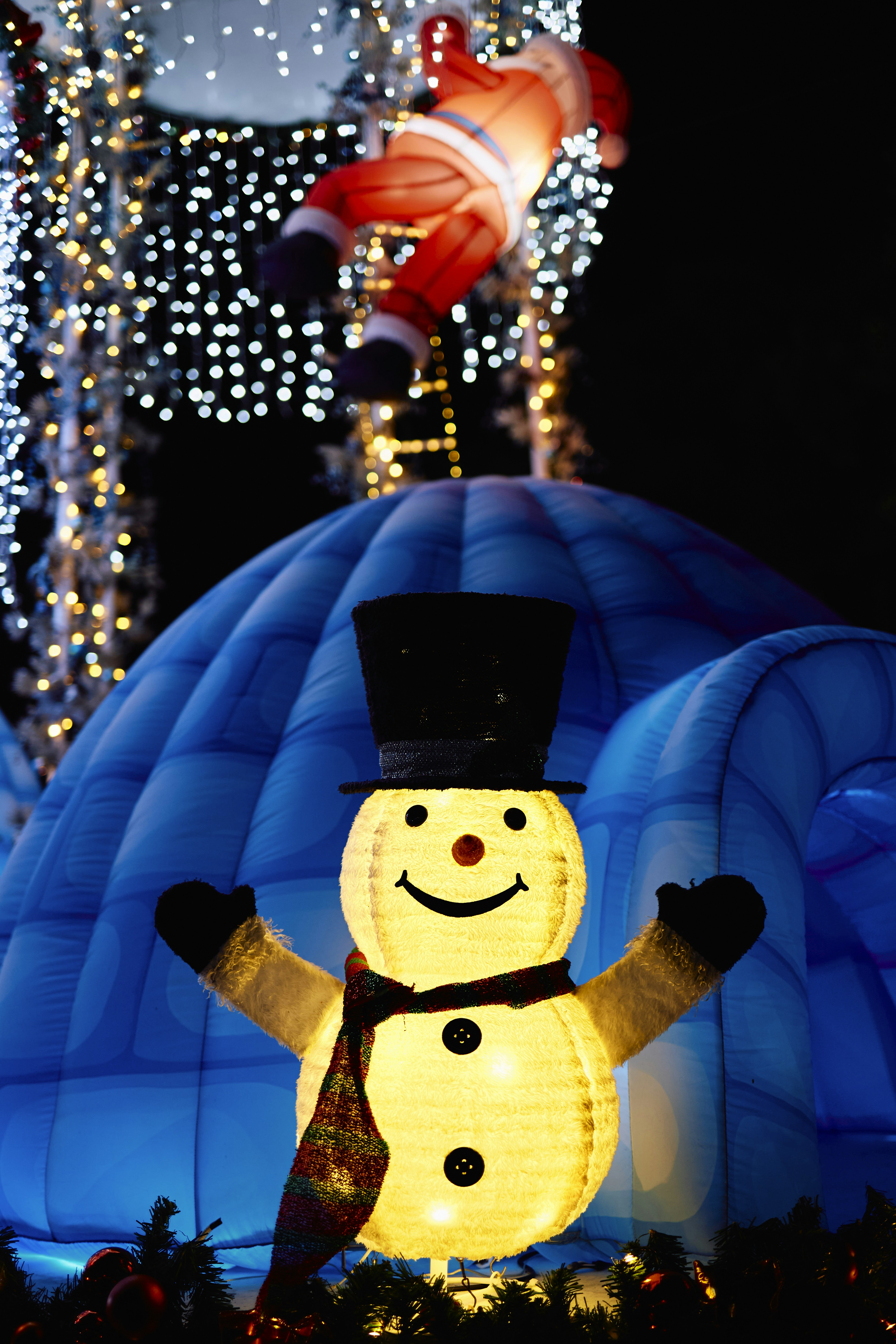 Glowing Snowman Beneath a Night of Festive Lights