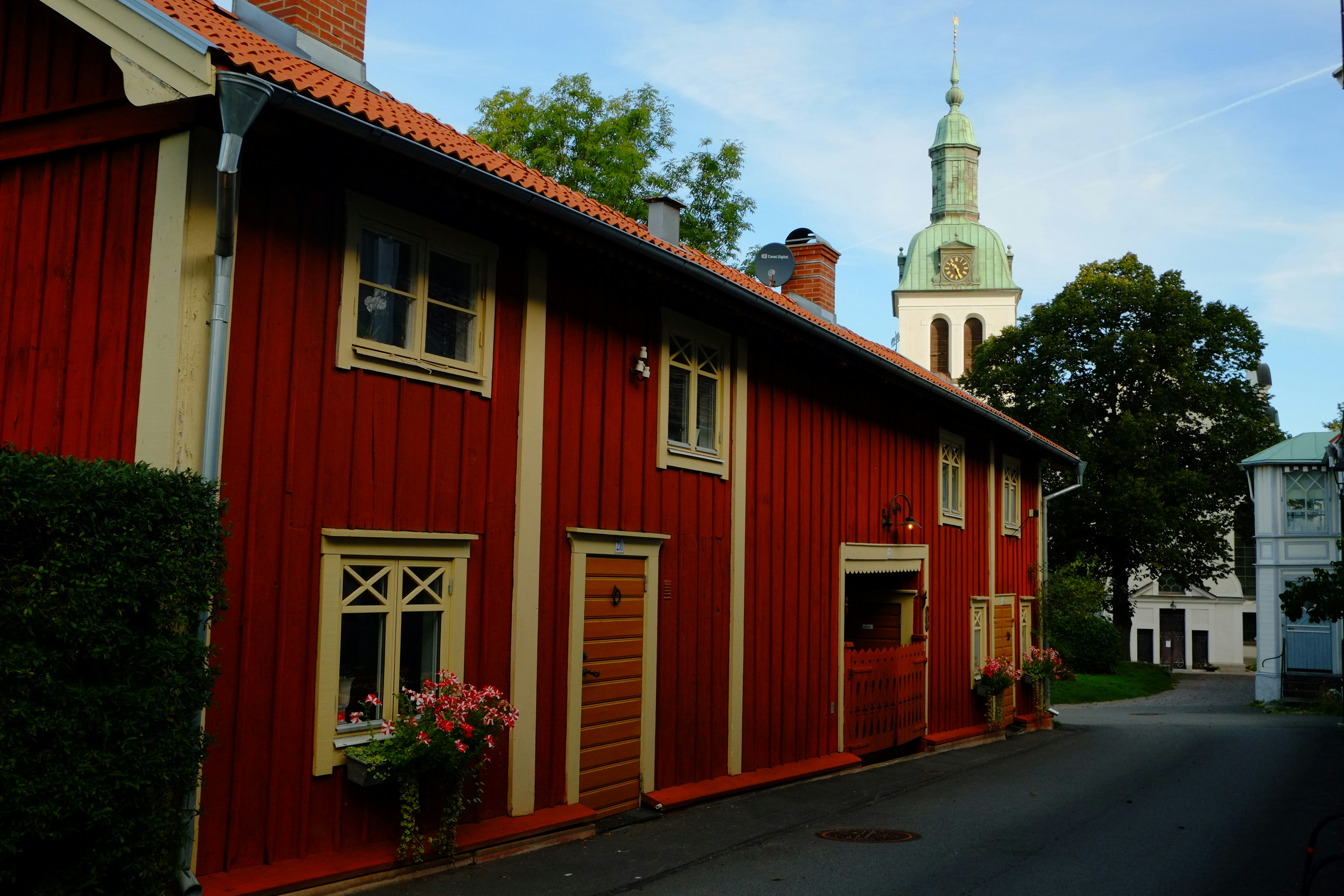 Red Wooden Row with Clock Tower in the Distance