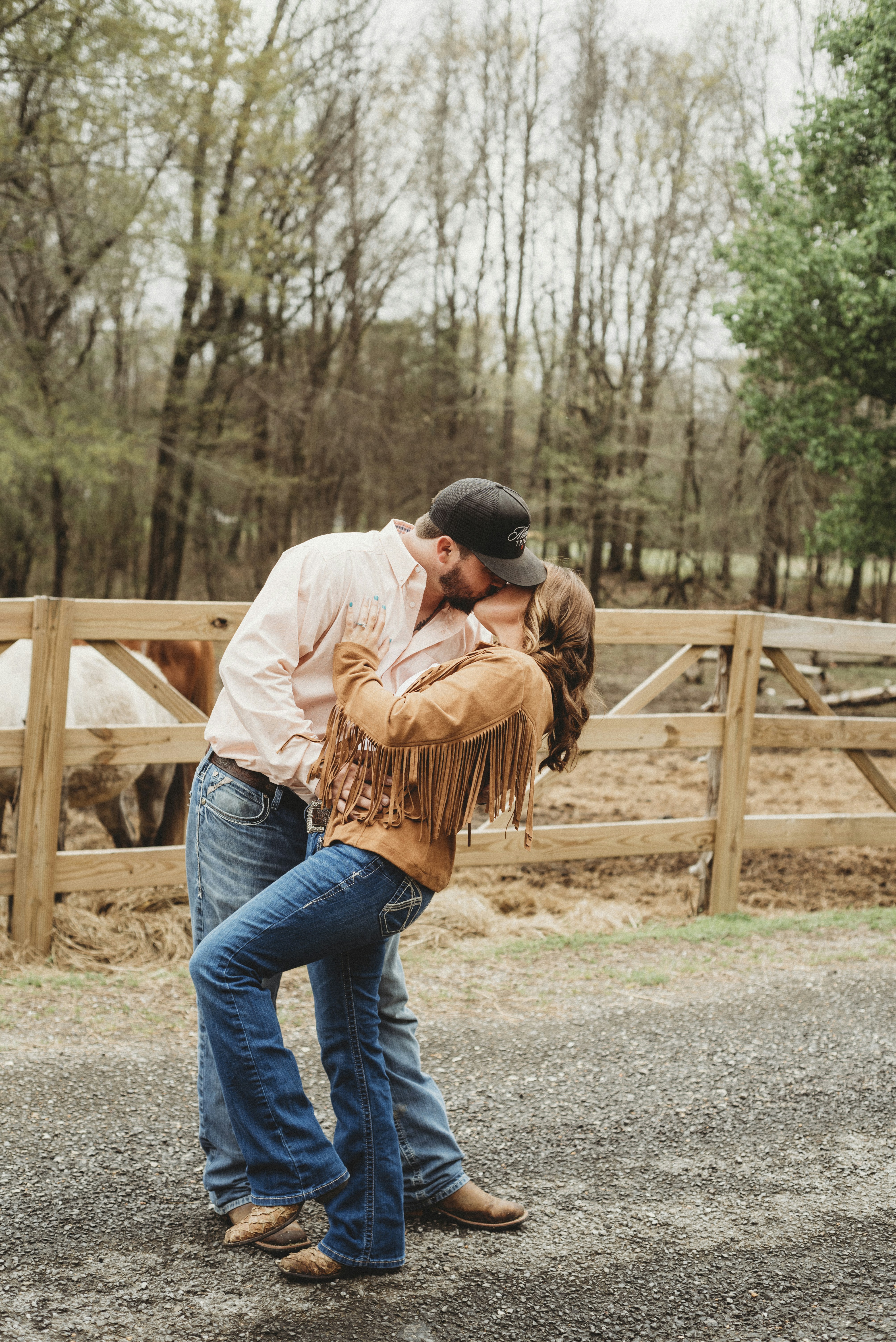 Close embrace under a rustic fence