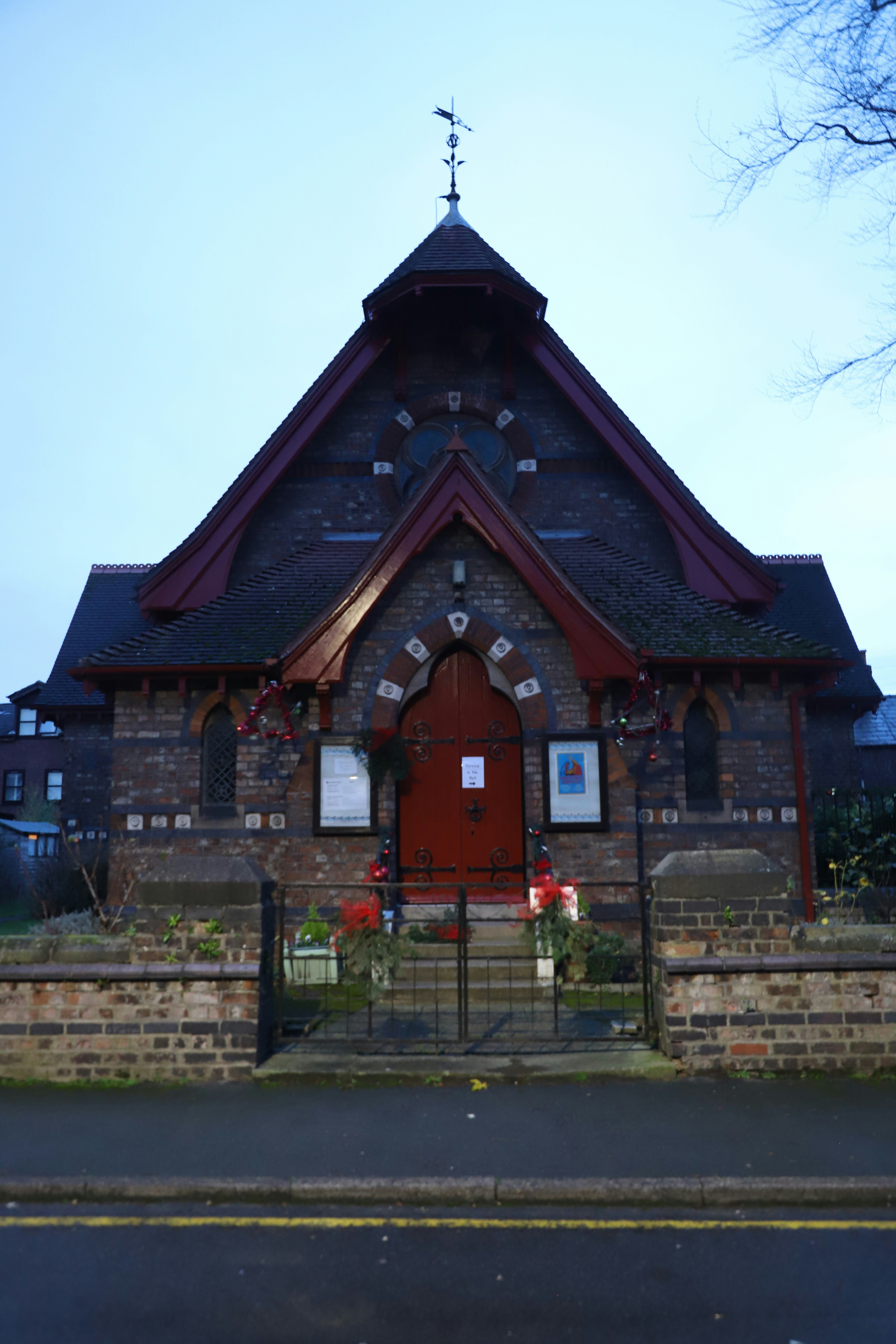Gothic Chapel Facade: Brickwork, Wrought Iron Gate, and Red Door