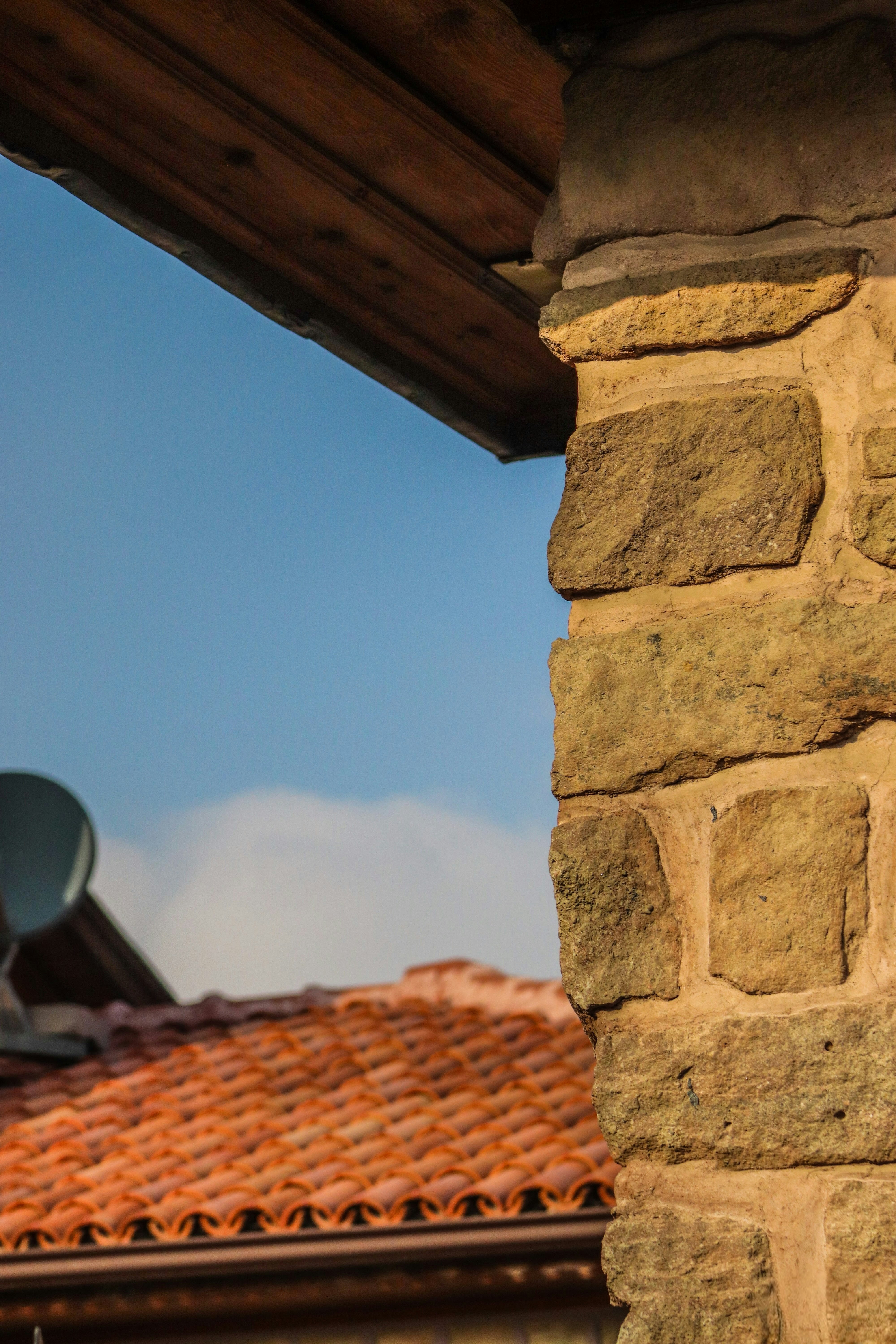 Limestone Column in Golden Hour Light beside Tile Roofs