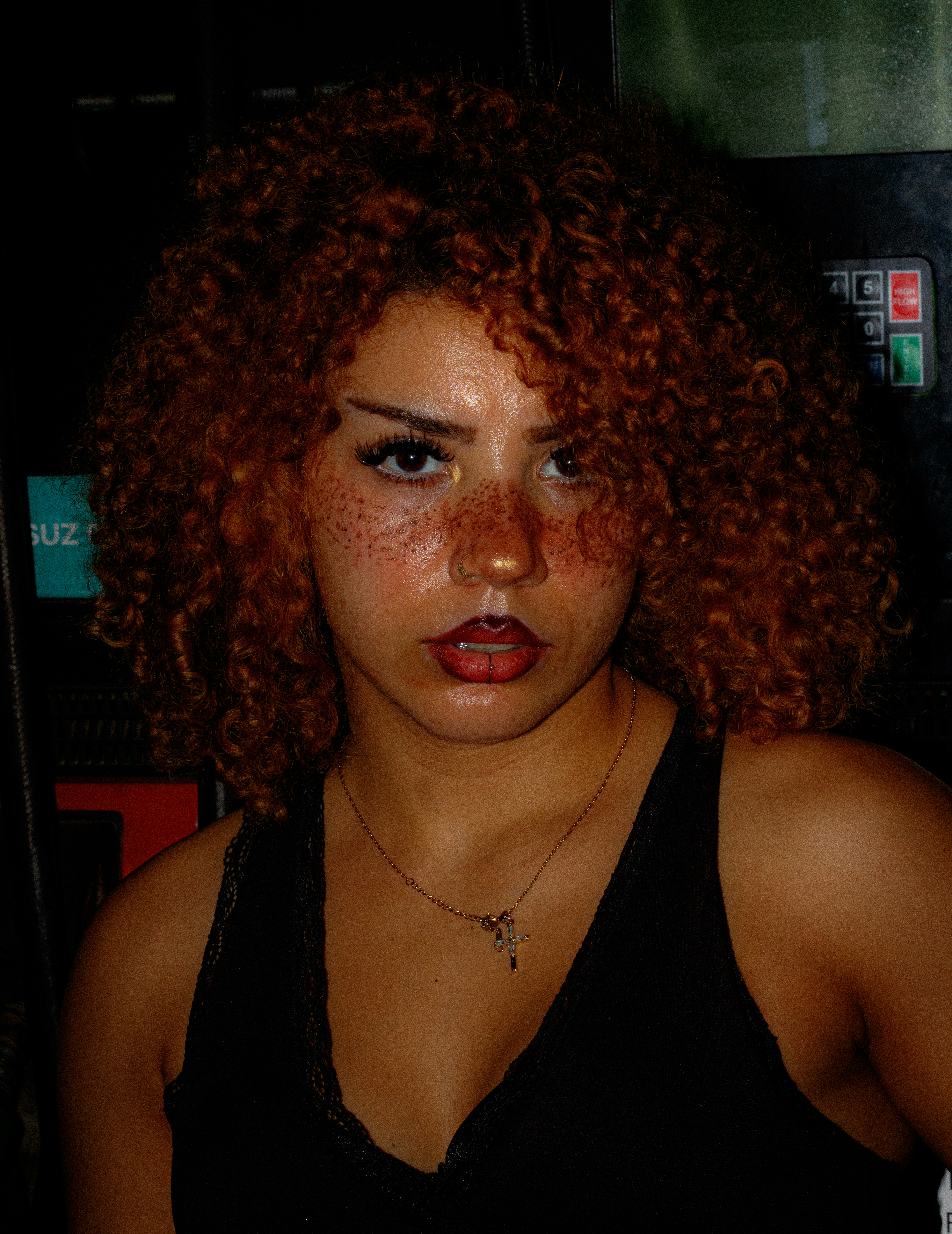 Faceted Confidence: Freckled Gaze Under Dim Neon Lights