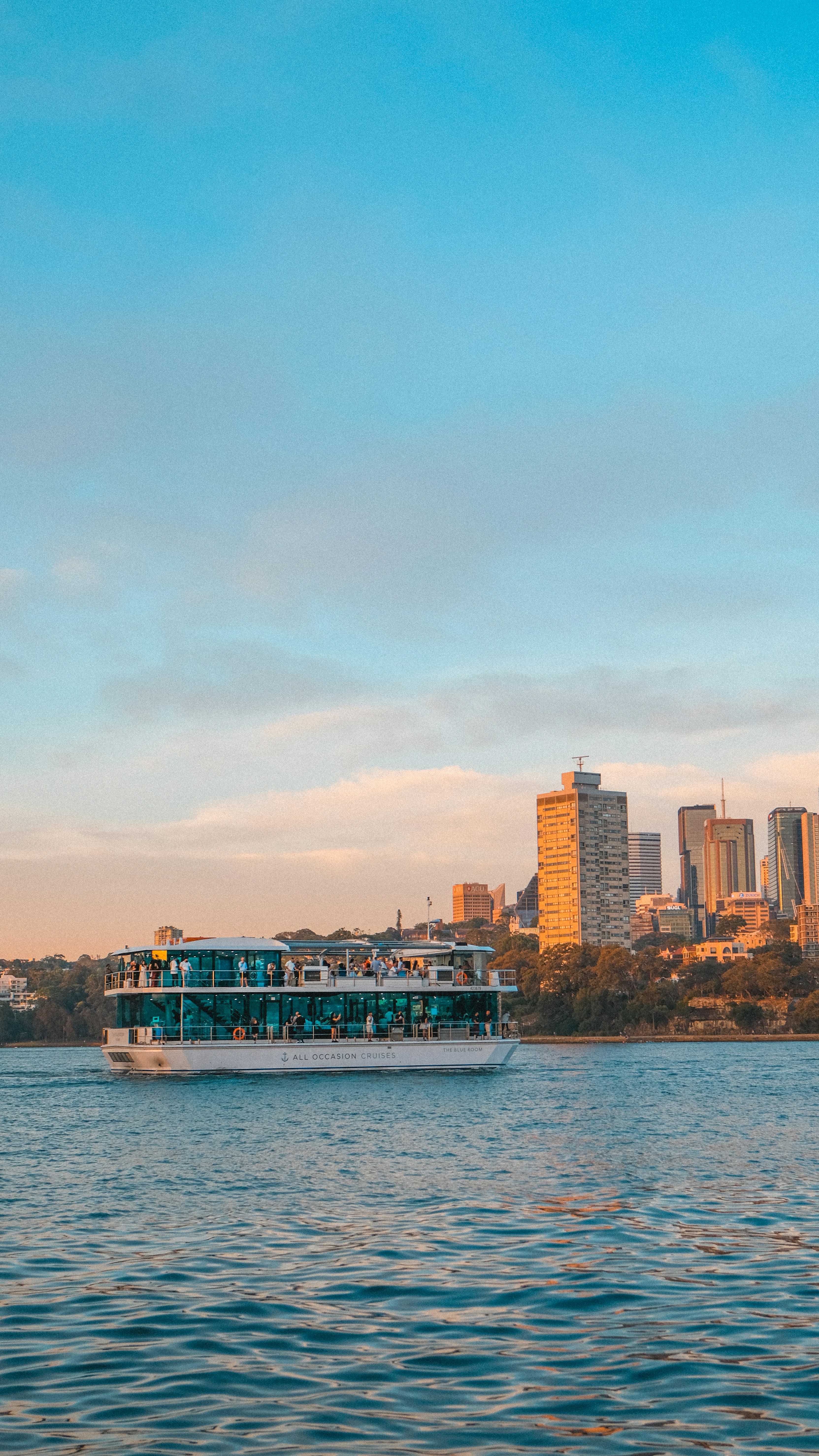 Sunlit City and Riverfront: A Dual View of Vessel and Skyline