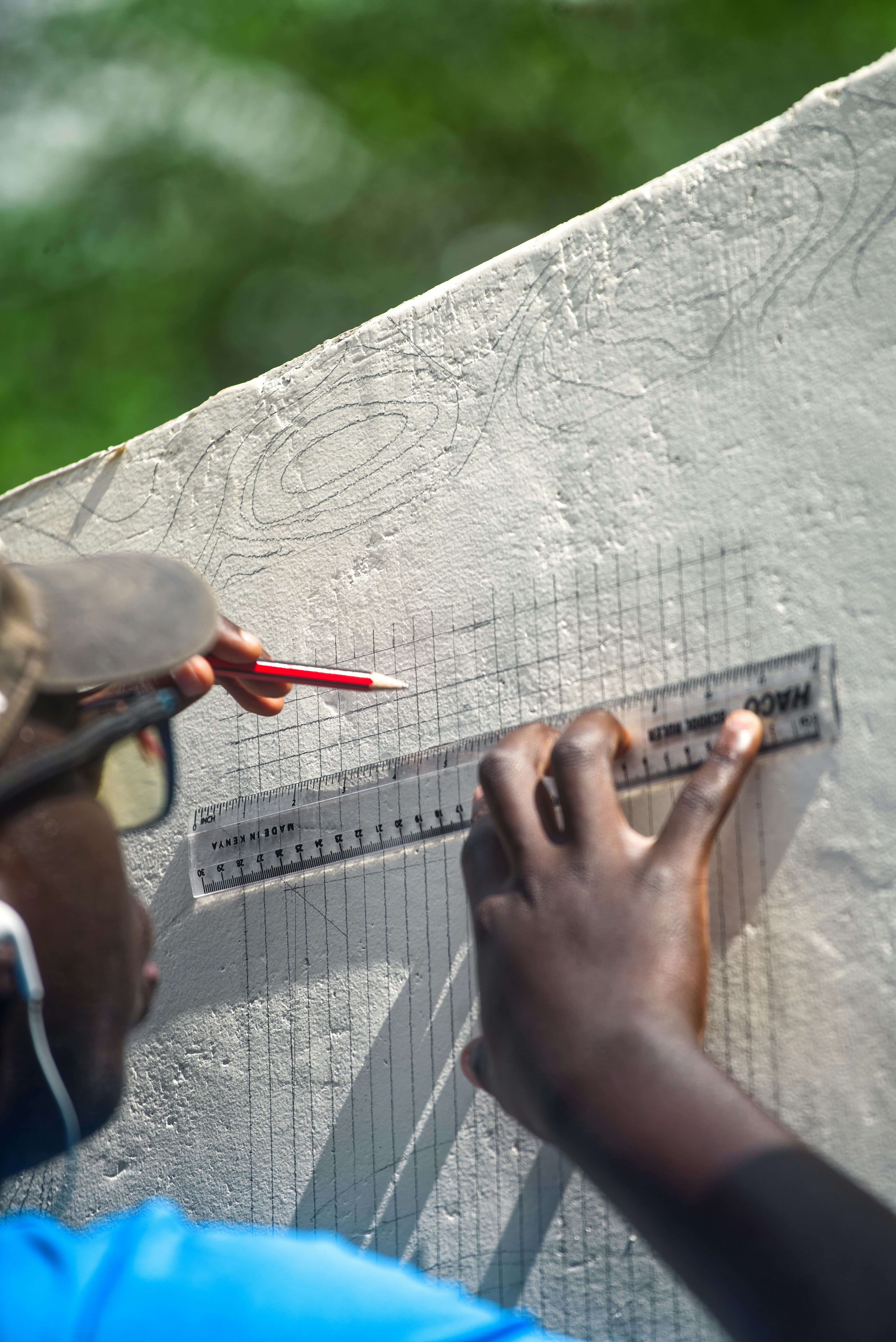 Person drawing grid lines on concrete with ruler. photo – Free Building ...